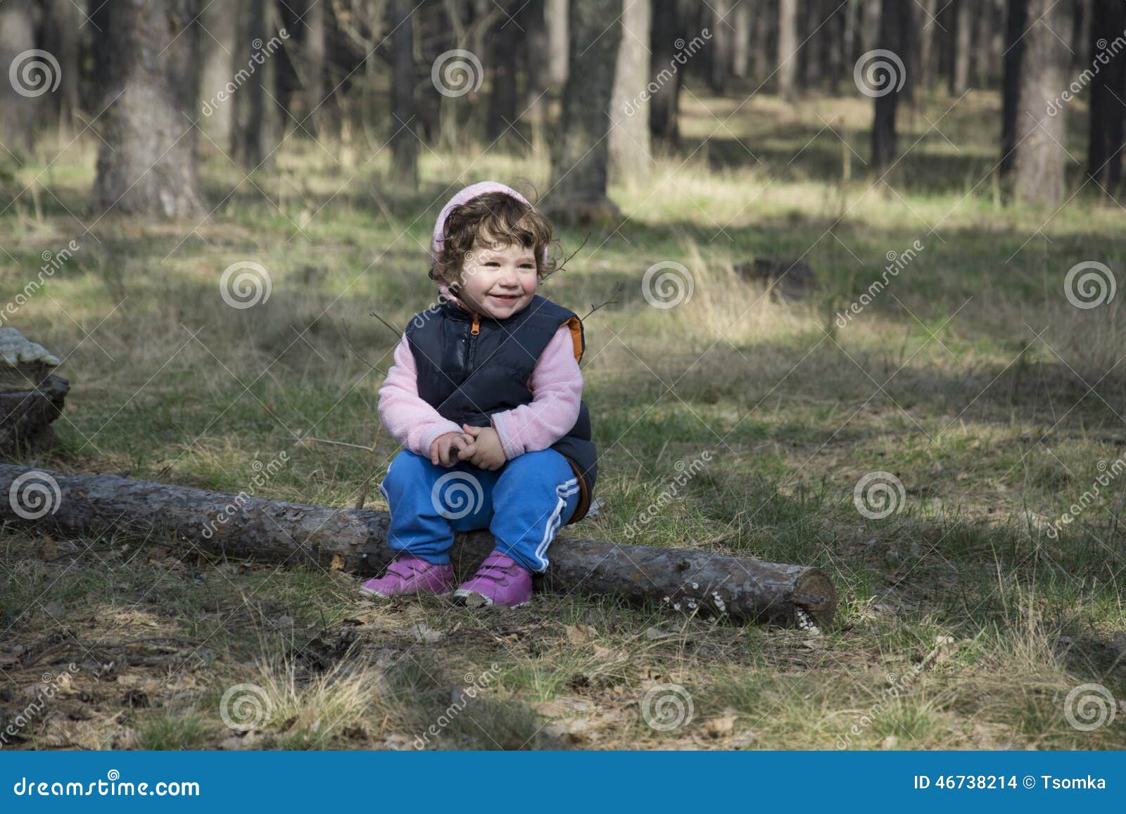 In the Spring of a Little Girl Sitting on a Log in the Forest. Stock ...