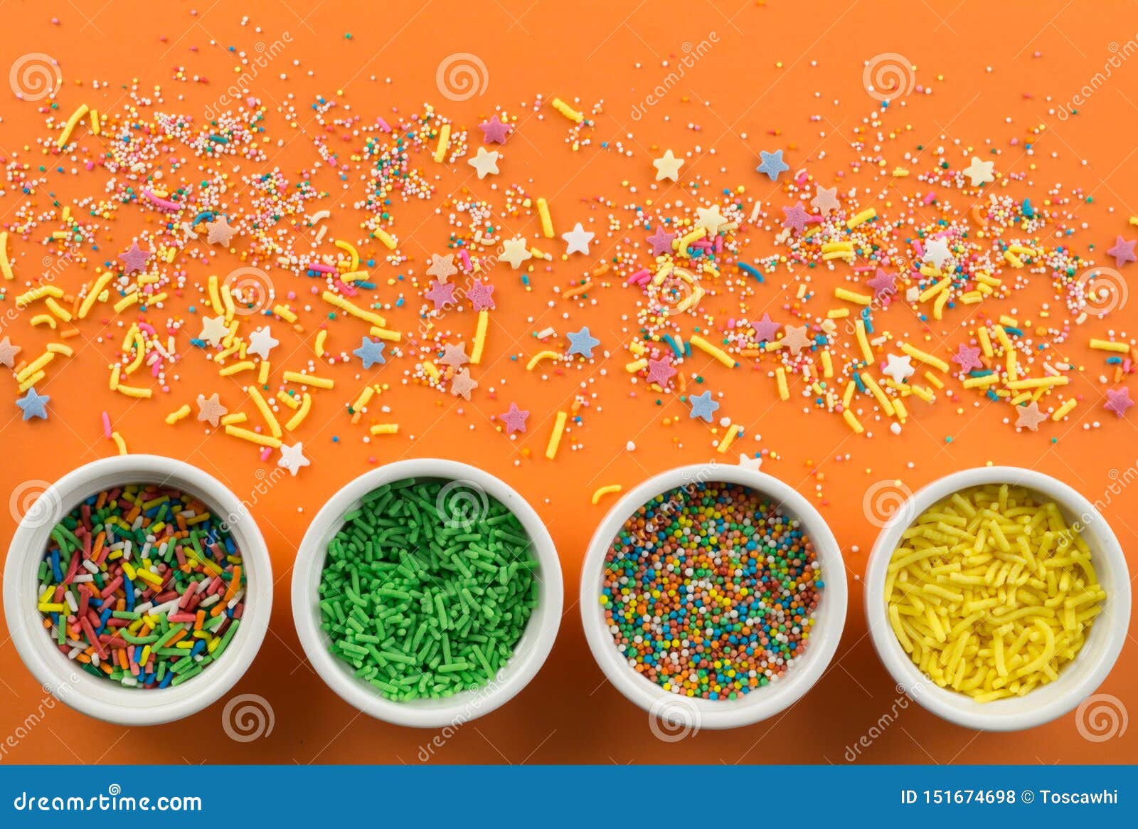 Sprinkles on Bright Orange Background with Little White Bowsl at Bottom ...