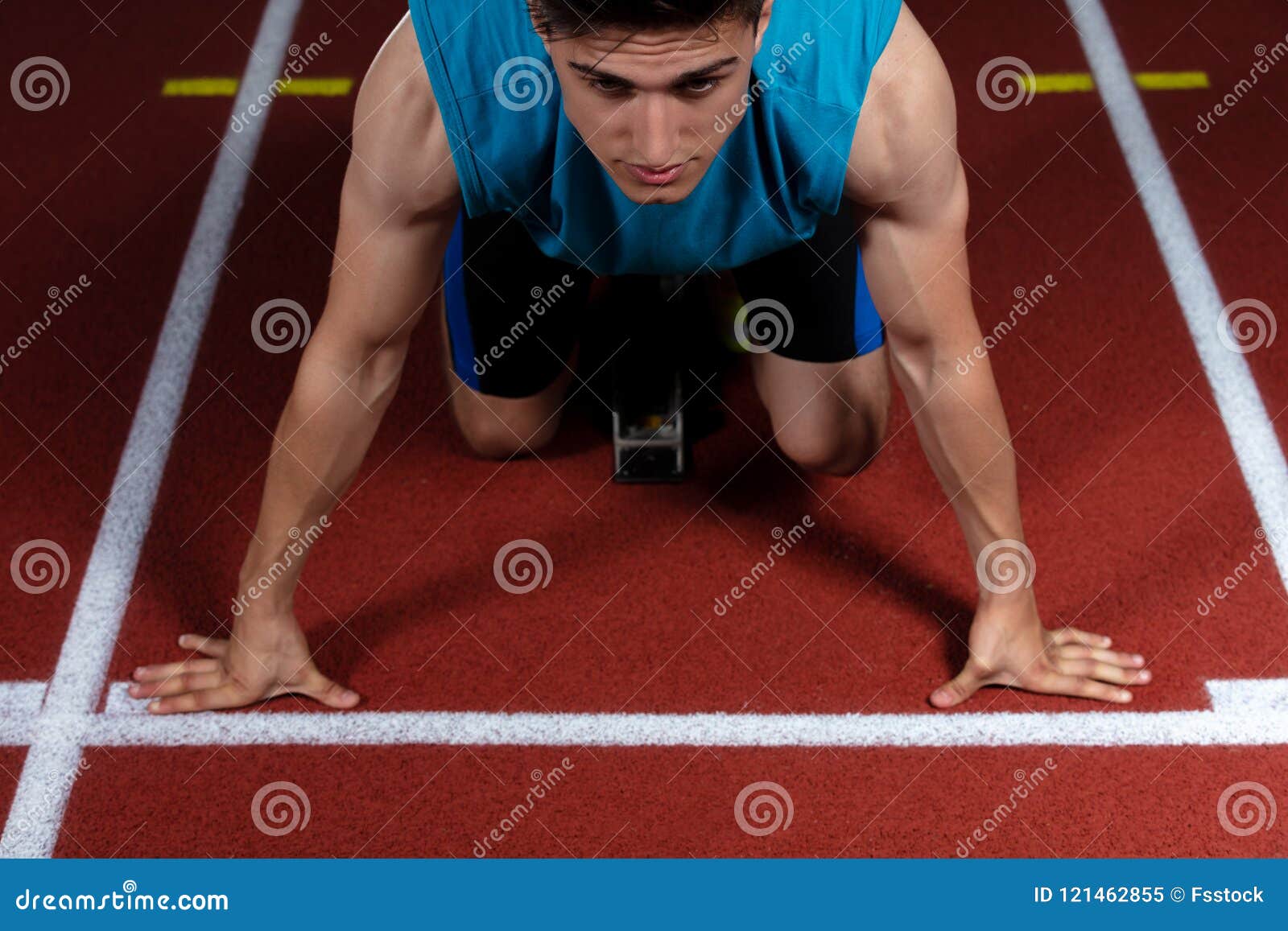 Sprinter Leaving Starting Blocks on the Running Track in Front of Big ...