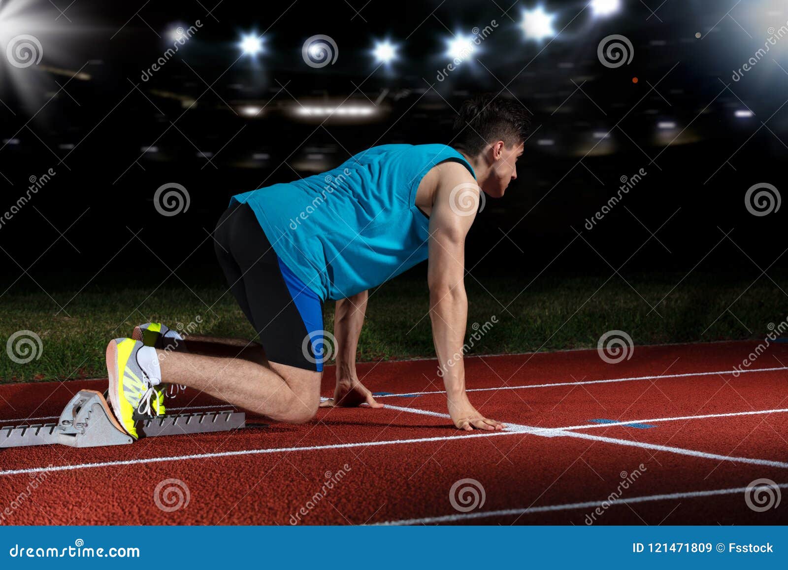 Sprinter Leaving Starting Blocks on the Running Track in Front of Big ...