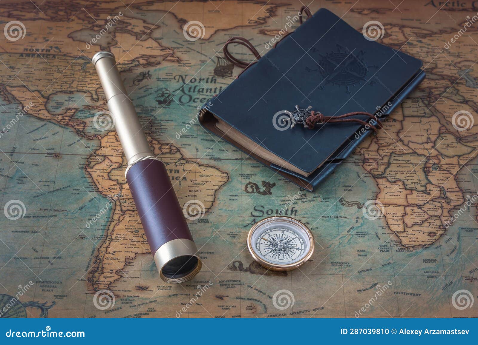 Spyglass, a Compass and a Leather-bound Book Lie on an Old Map Stock ...