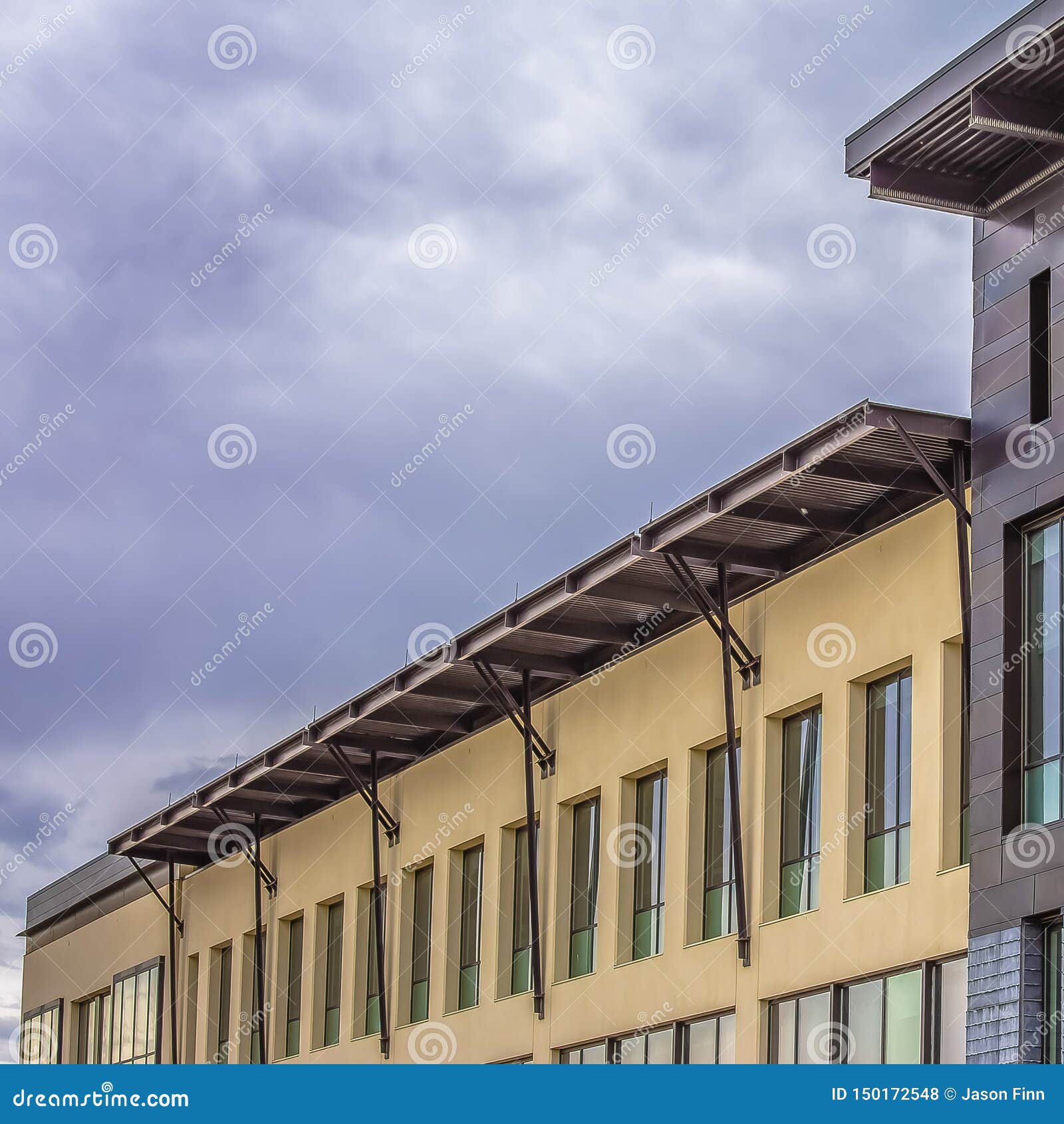 Square Building Exterior with a Flat Roof Against Sky Covered with ...