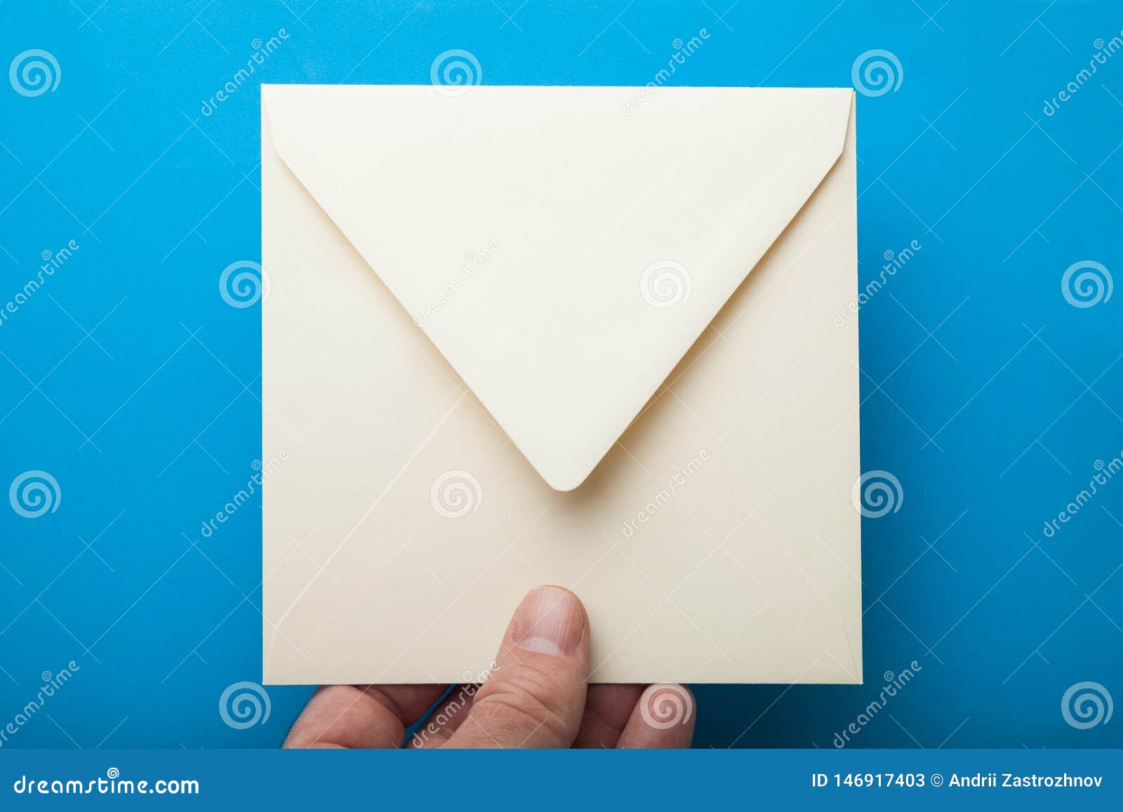 A Square Envelope in Hand on a Blue Background Stock Image - Image of ...