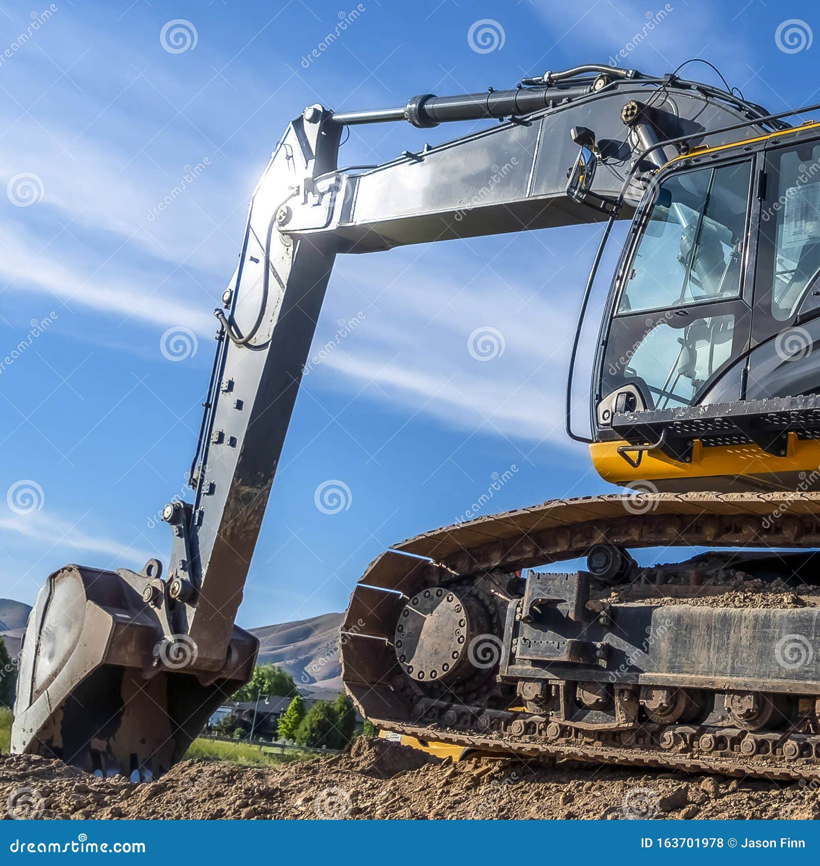 Square Frame Yellow Excavator with Continuous Tracks Digging Soil at a ...