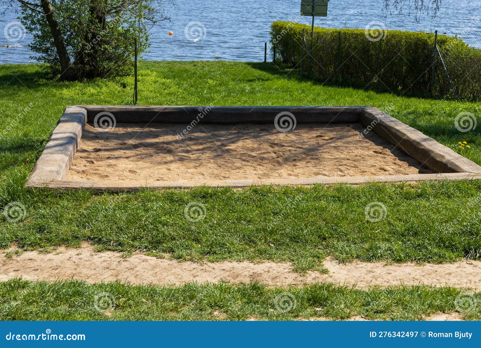 A Square Sandpit for Children in a Meadow by the Water Stock Image ...