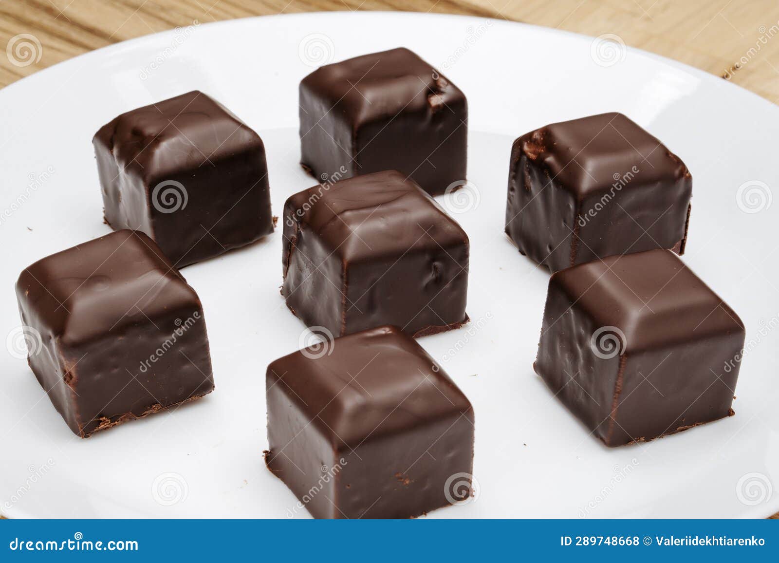 Square-shaped Chocolates on a White Plate on the Table Stock Photo ...