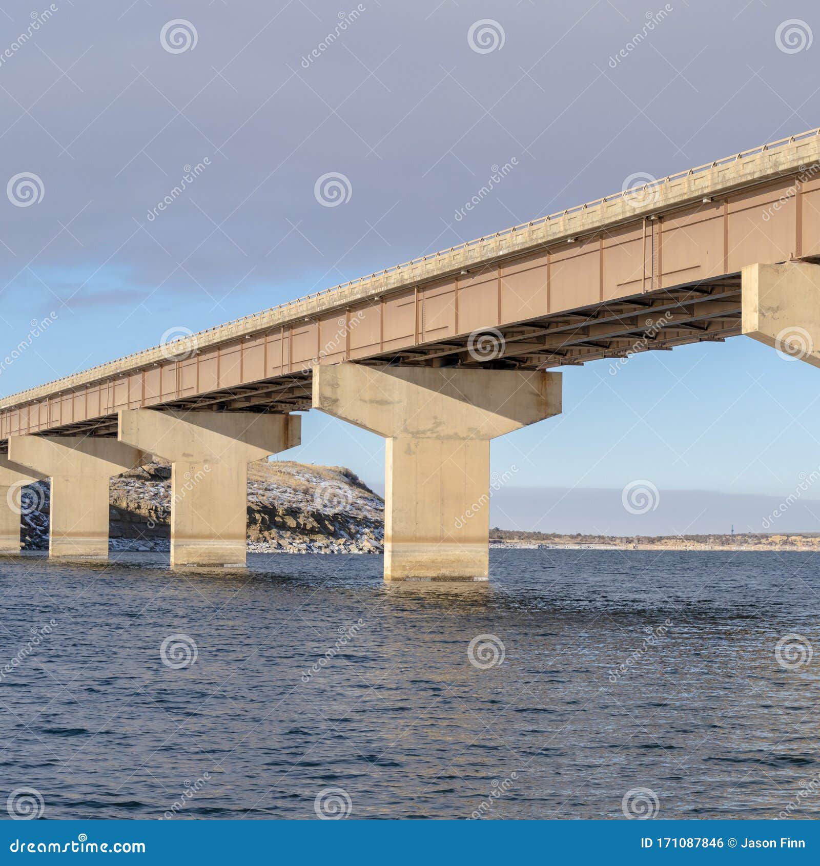 Square Stringer Bridge Spanning Over a Lake with View of Snowy Terrain ...
