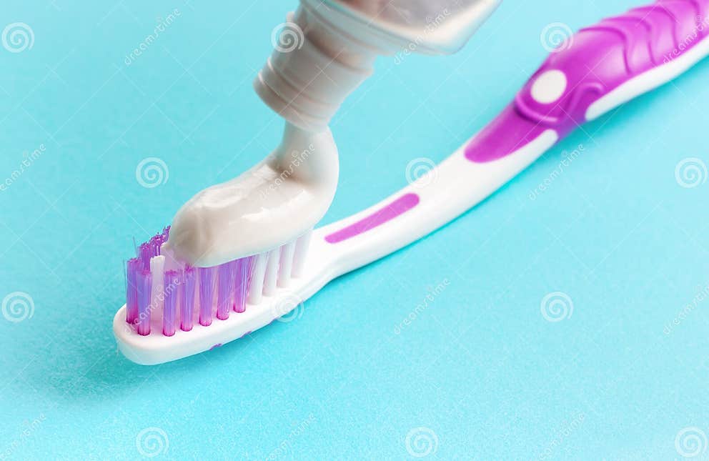 Squeezed Out Toothpaste on a Toothbrush on Blue Background Close-up ...