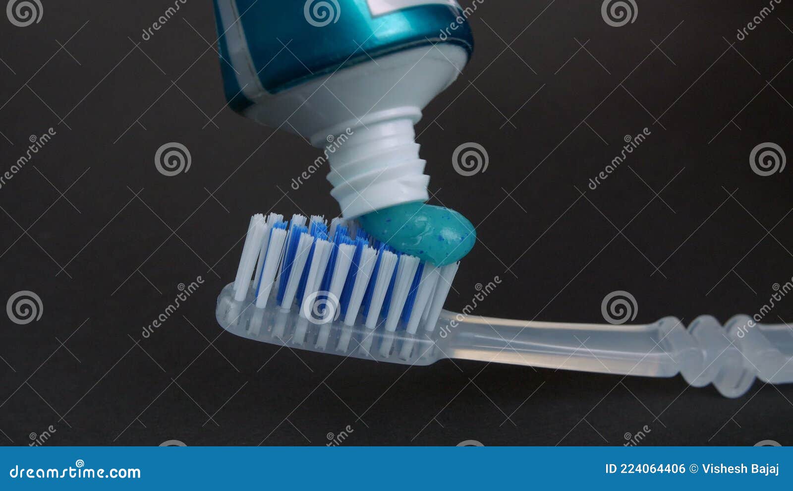 Squeezing or Spreading or Applying of Blue Toothpaste on a Grey ...