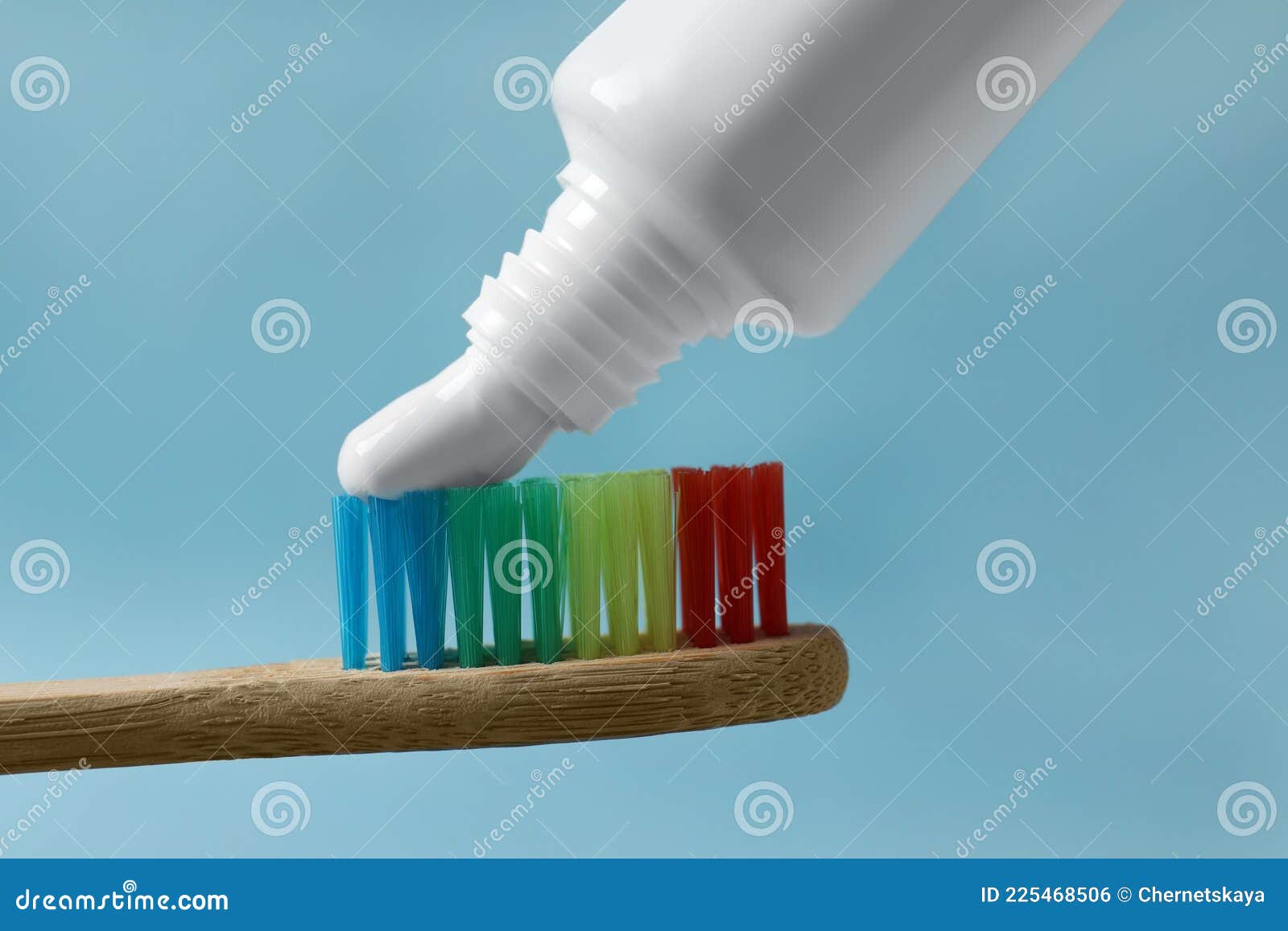Squeezing Toothpaste Onto Brush Against Blue Background, Closeup Stock ...