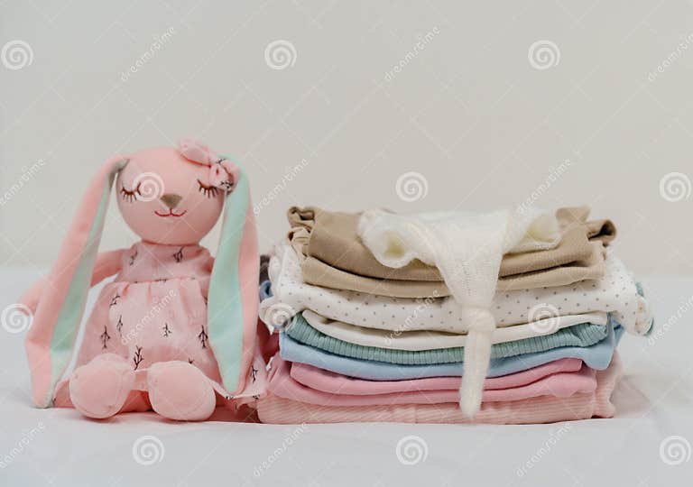 Stack of Baby Clothes and Toy on Bed Stock Image - Image of background ...