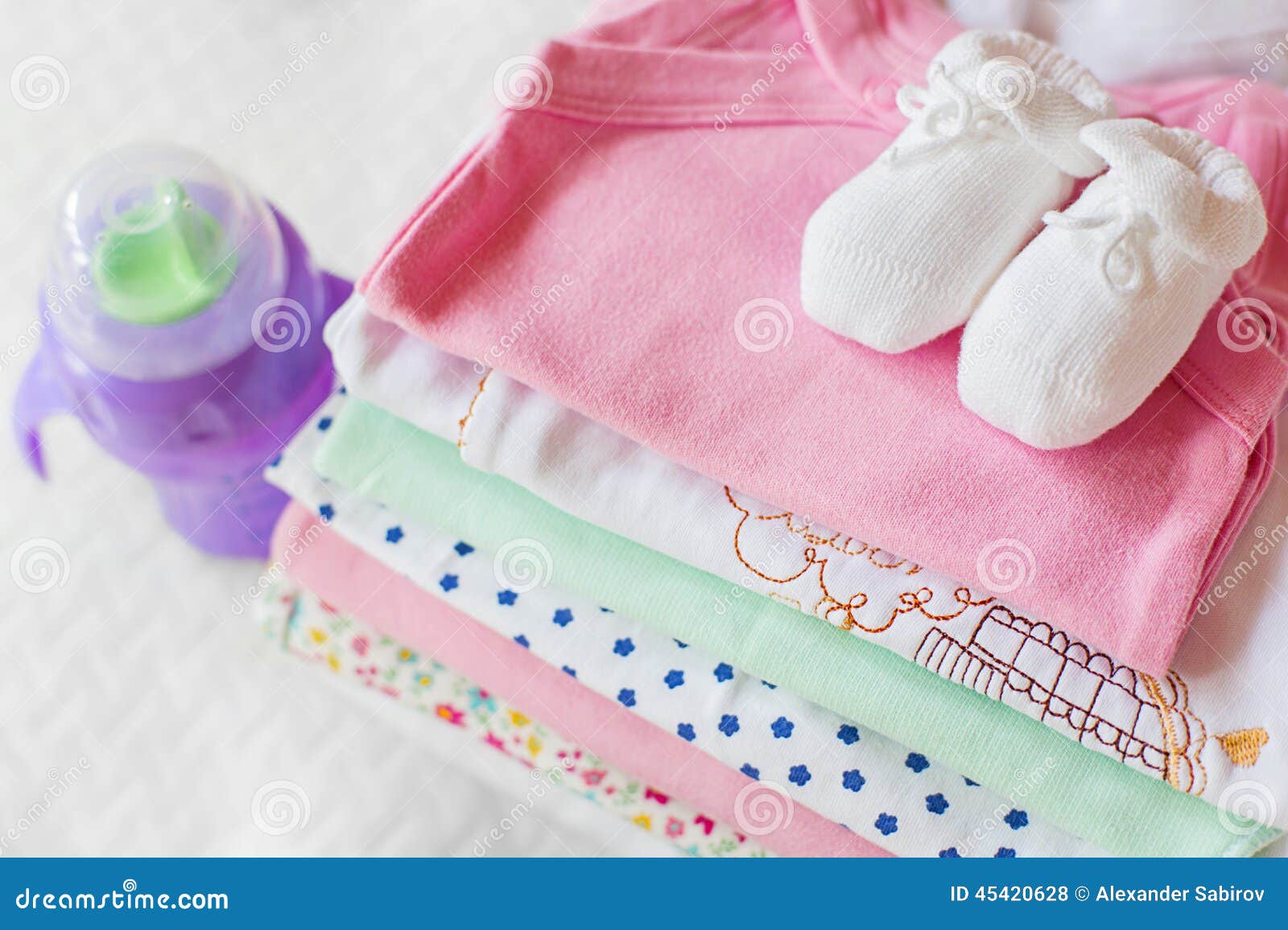 Stack of Baby Clothing with a Feeding Bottle Stock Photo - Image of ...