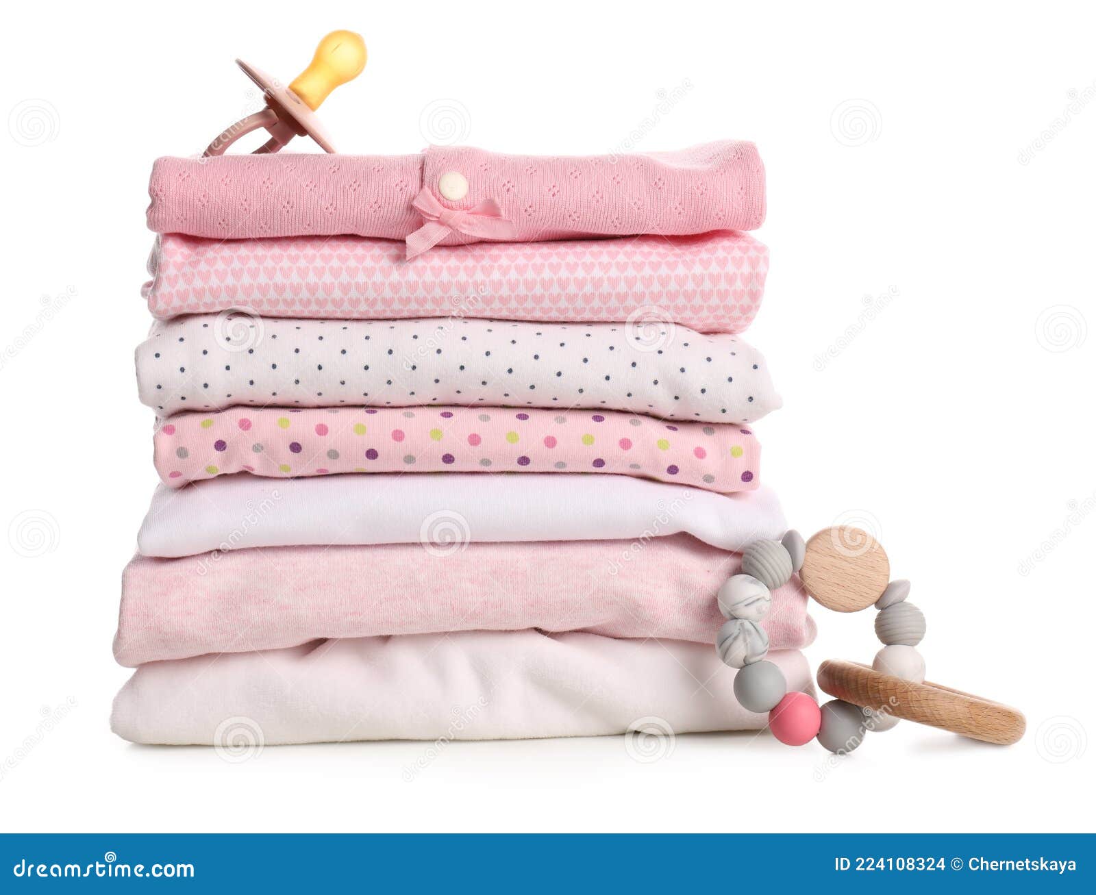 Stack of Baby Girl`s Clothes, Pacifier and Rattle on White Background ...