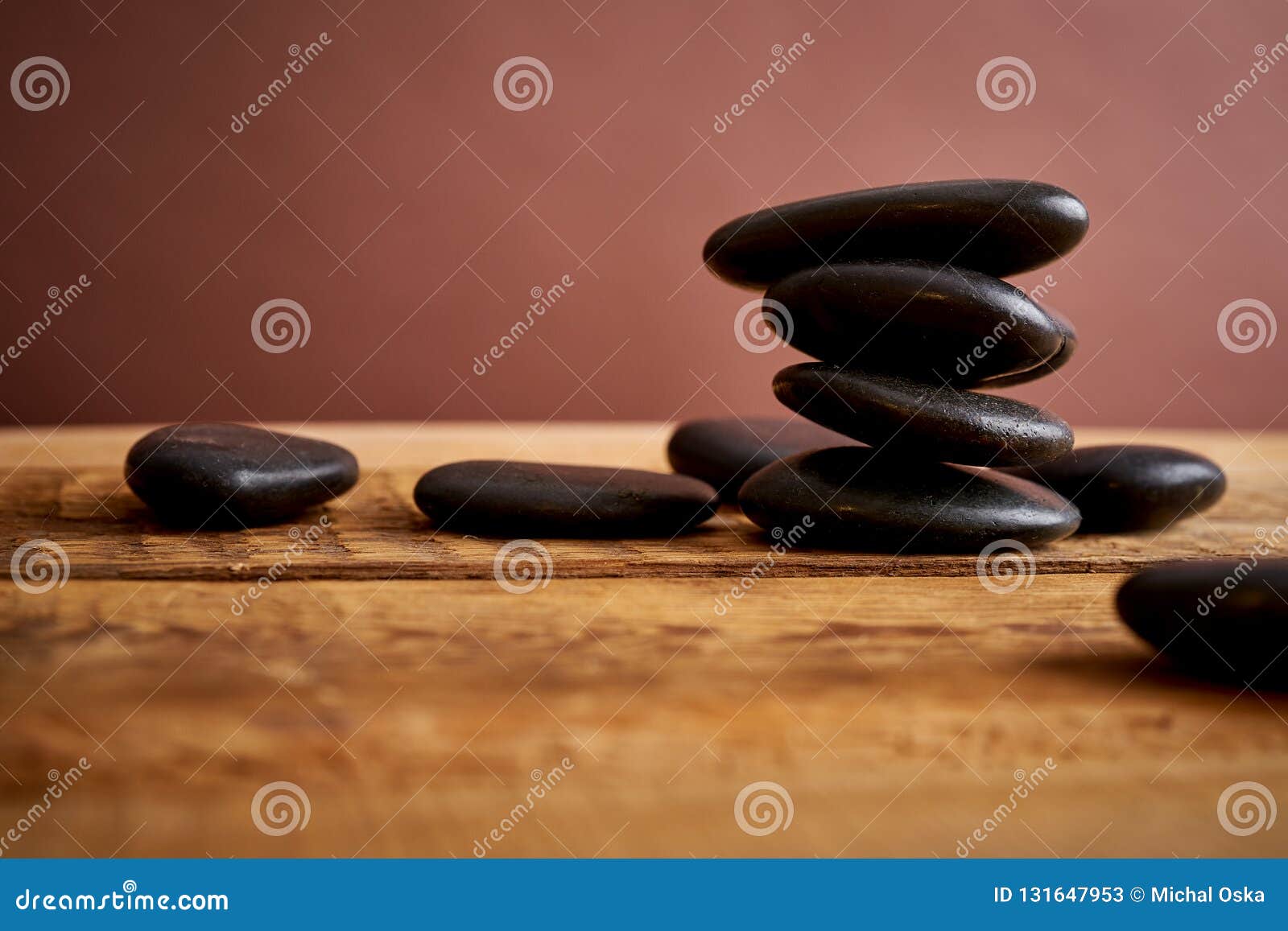 Stack of Black Spa Stones for Massage on a Brown Background and an ...