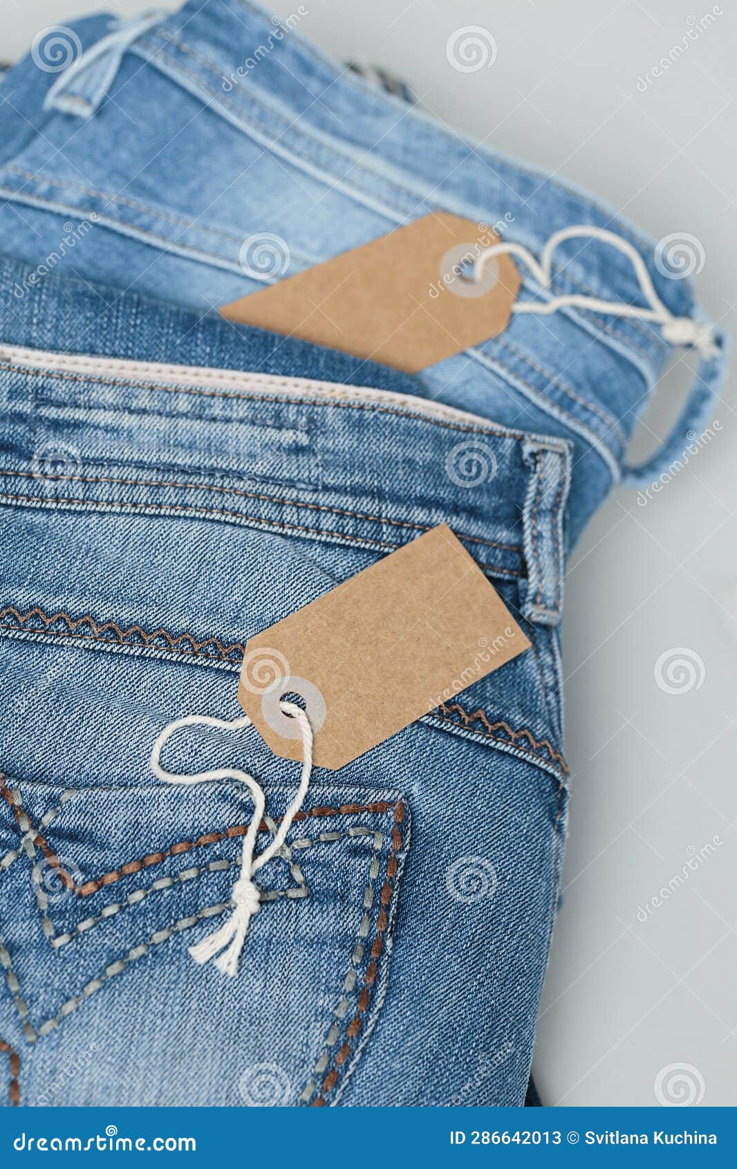 Stack of Blue Jeans and Empty Tags on White Background Stock Image ...
