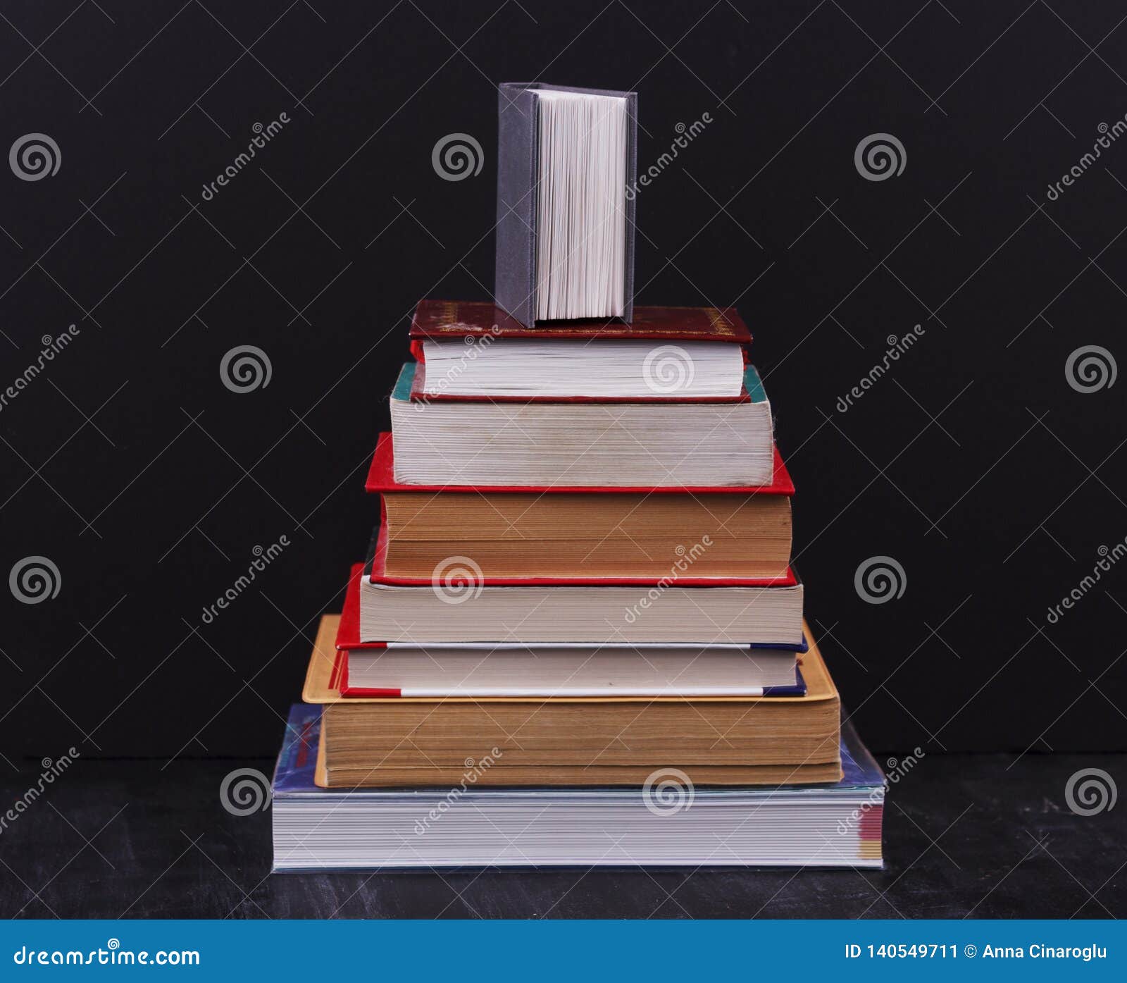 Stack of Books on a Black Background with Small Book on Top Stock Image ...