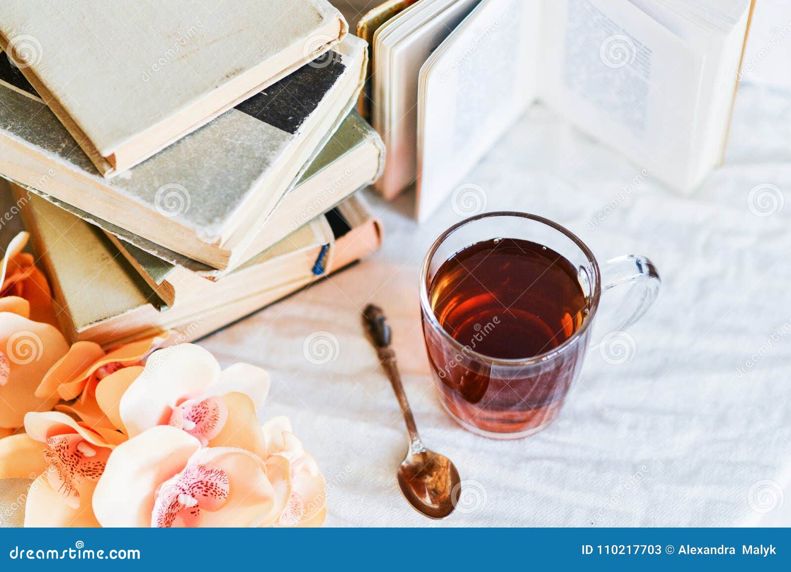 A Stack of Books, a Book and Tea in a Glass Cup on Bright Background ...