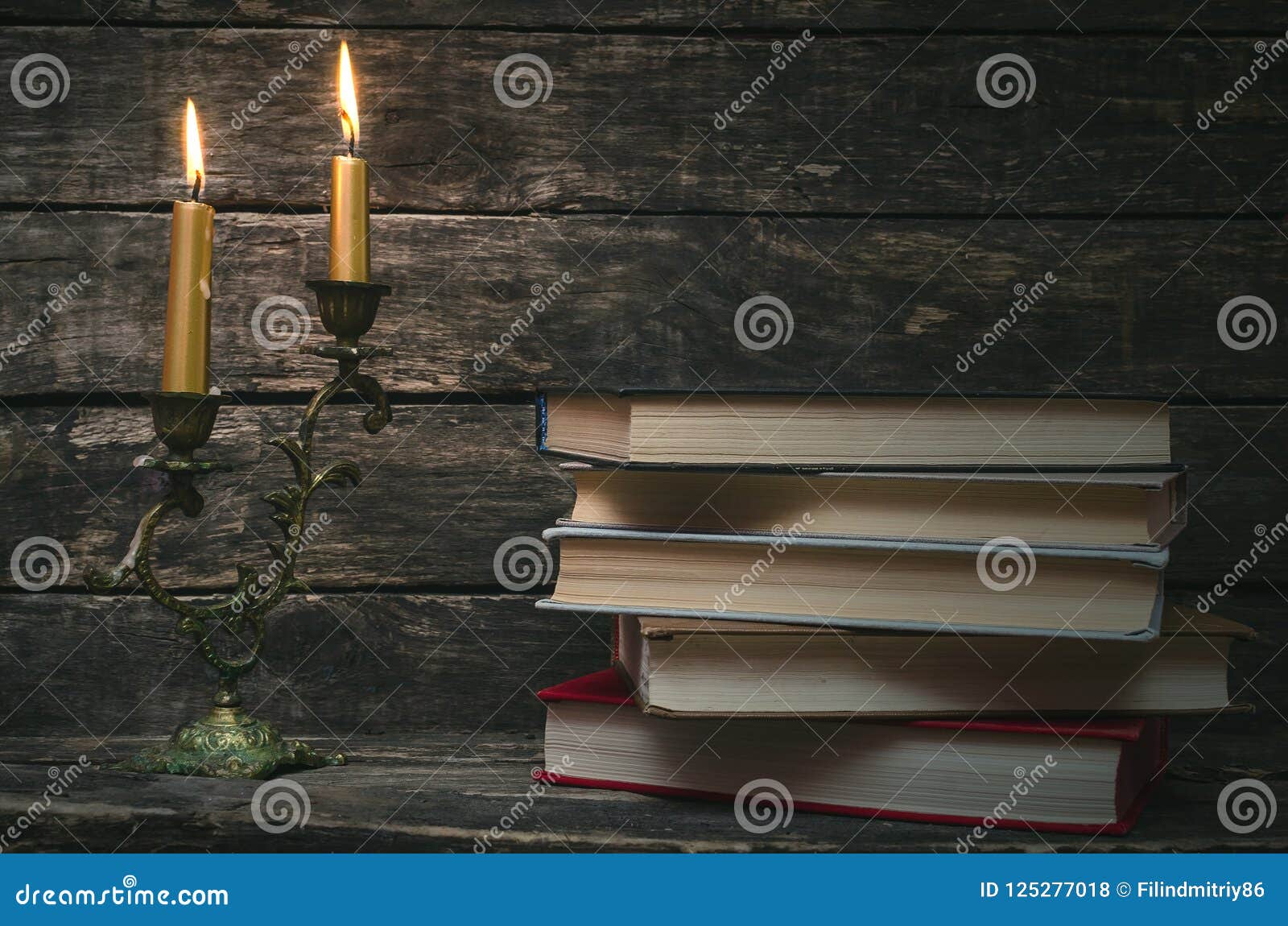Stack of books and candle. stock photo. Image of concept - 125277018