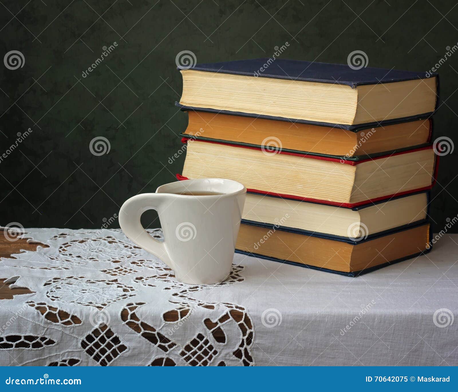 A Stack of Books and Cup of Tea on the Table with a White Tablecloth ...