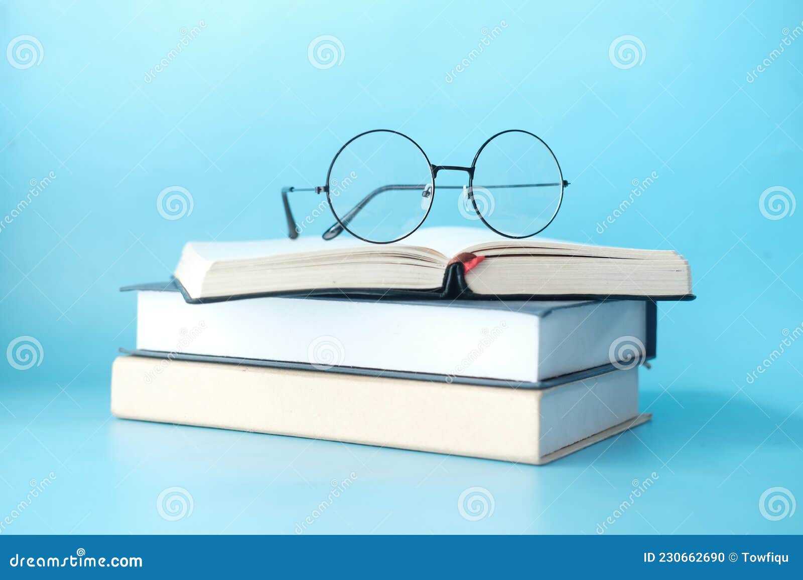 Stack of Books and Eyeglass on Blue Background Stock Photo - Image of ...