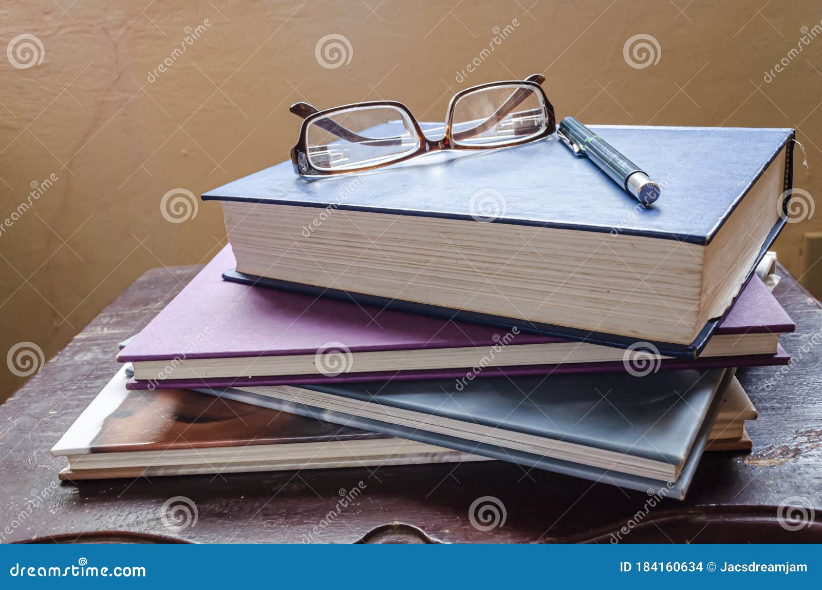 Stack of Books with Glasses and Pen at Top Stock Photo - Image of ...