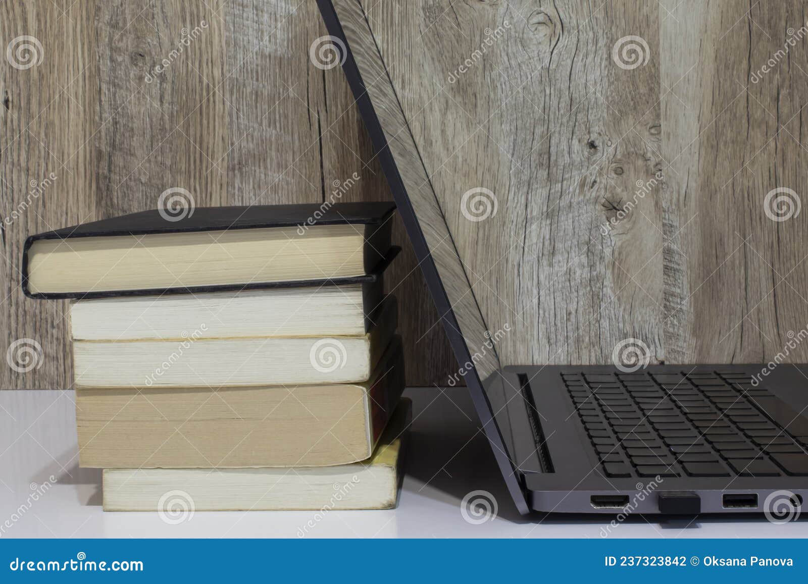 Stack of books with laptop stock photo. Image of exam - 237323842