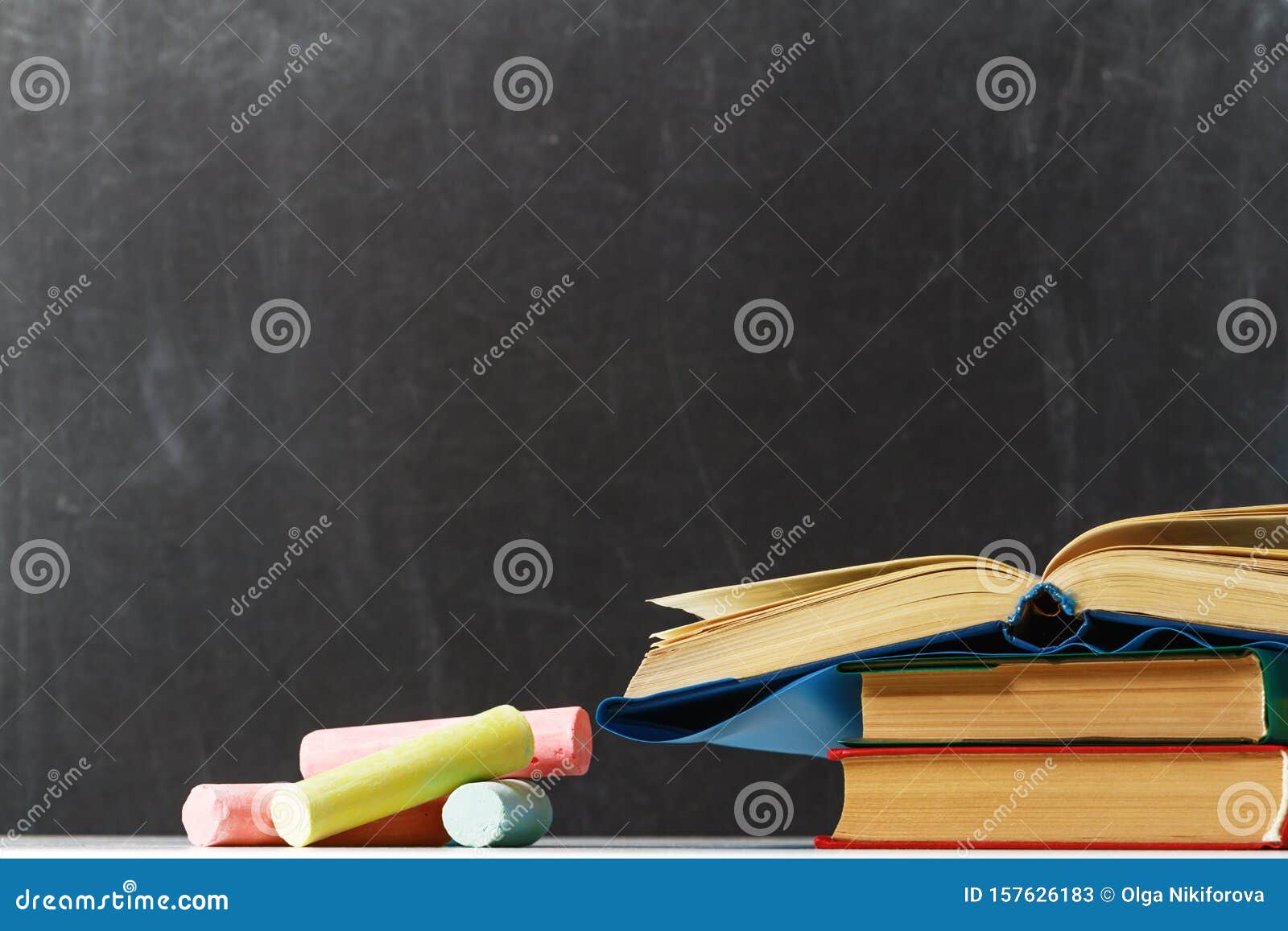 A Stack of Books and Multi-colored Chalk on the Background of the ...