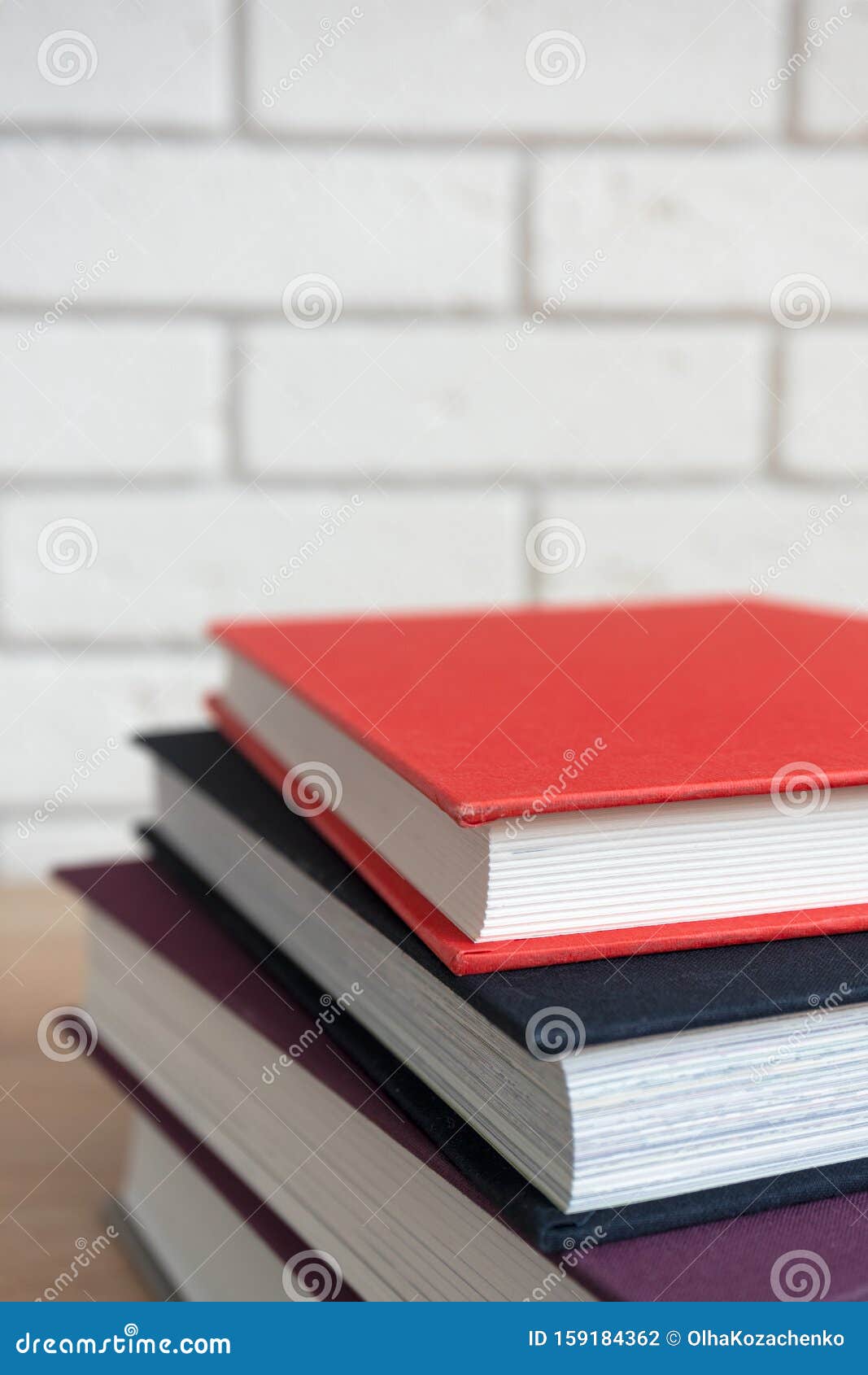 A Stack of Books with Multi-colored Covers on the Table with Blurred ...