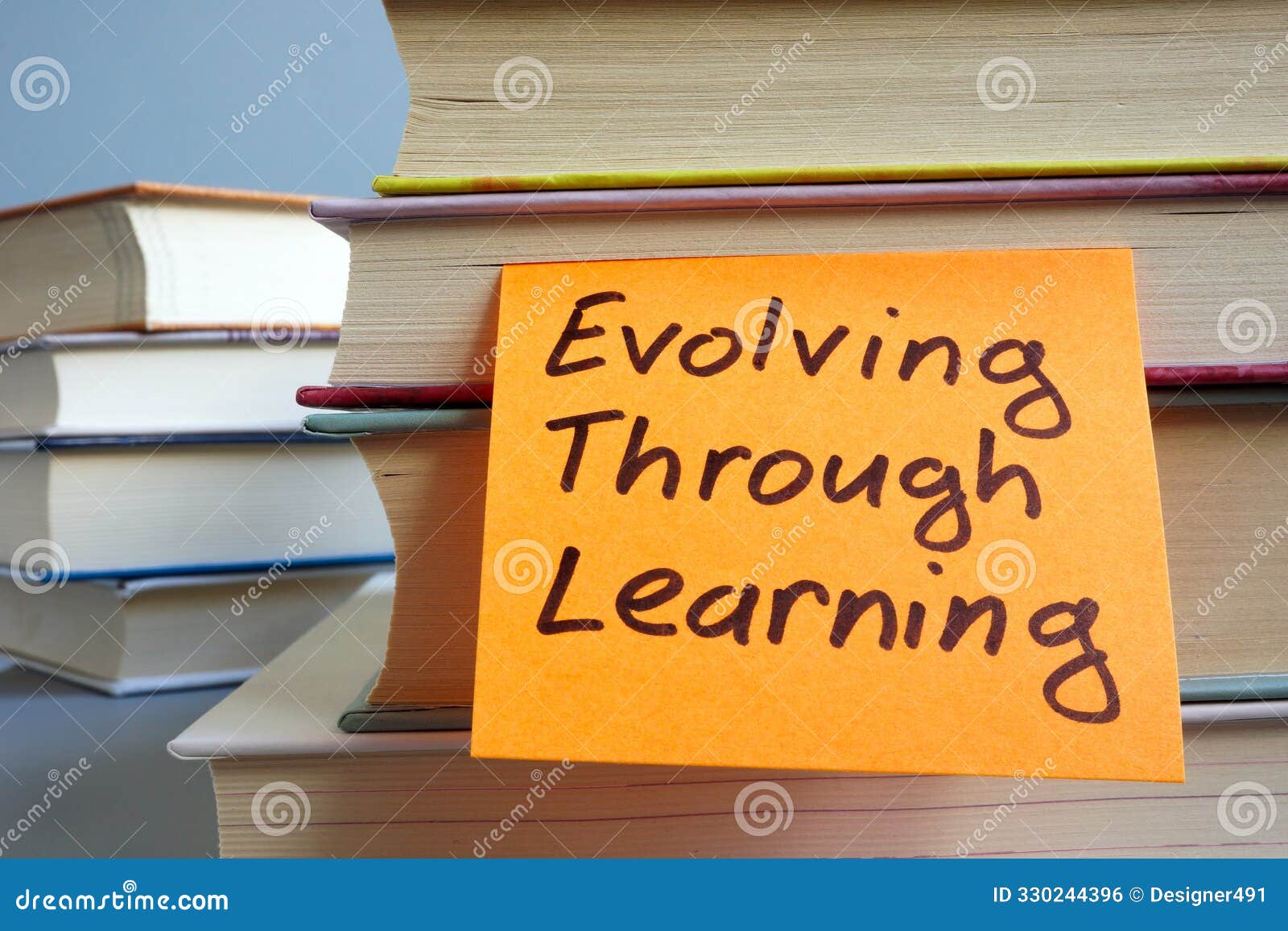 Stack Of Books With A Note Saying Evolving Through Learning. Personal ...