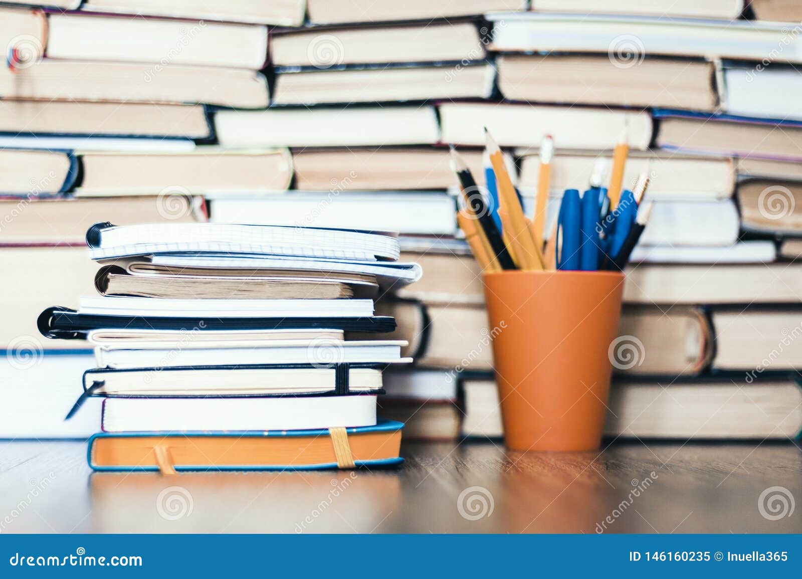 Stack of Books, Notebooks and Pencils in Plastic Holder on Wooden Table ...