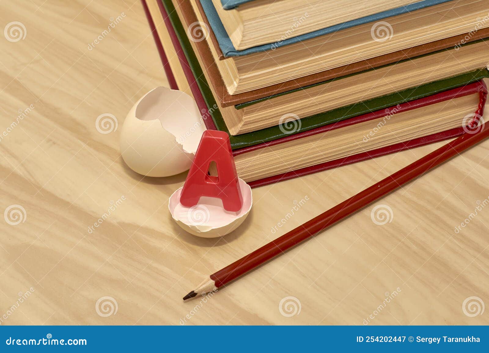A Stack of Books a Pencil and a Split Chicken Egg with the Letter a ...