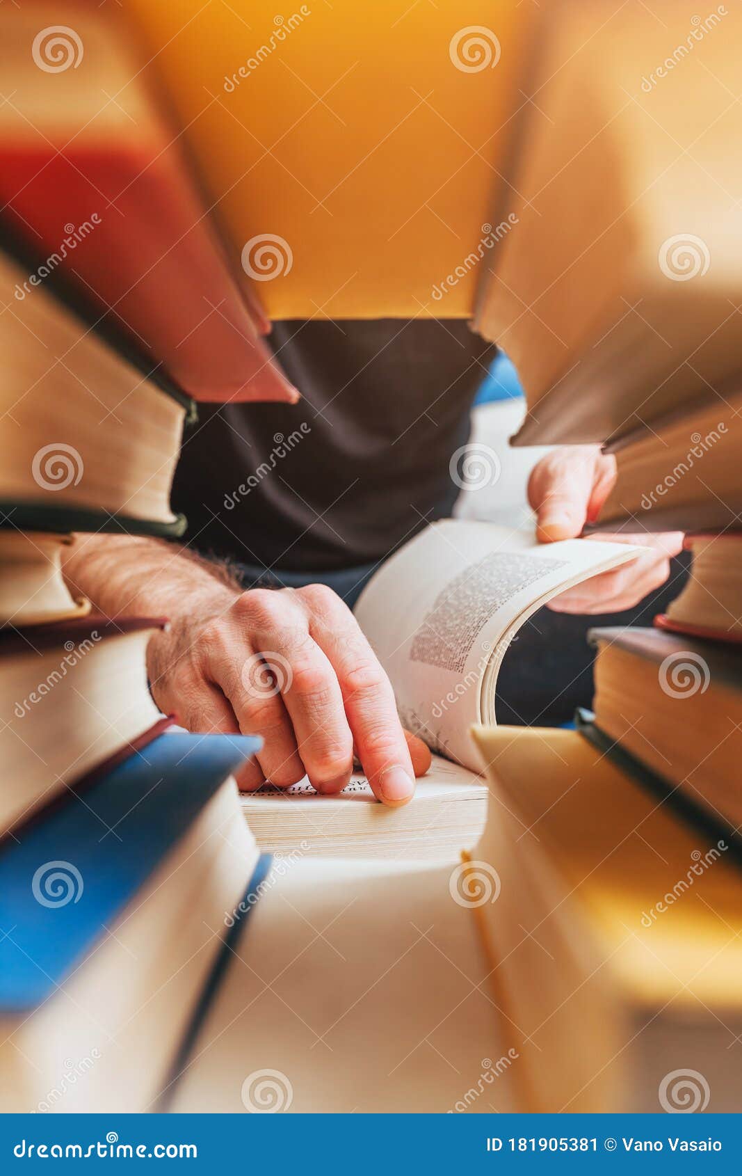 Through a Stack of Books a View of a Reading Man in a Library Stock ...