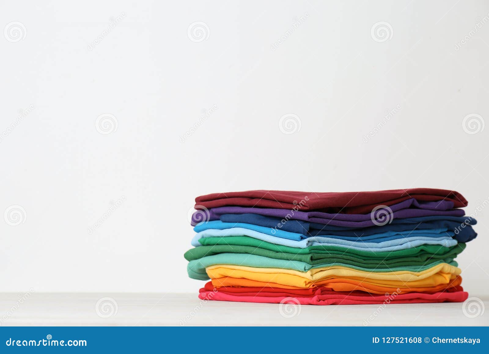 Stack of Bright Folded Clothes on Table Against White Background Stock ...