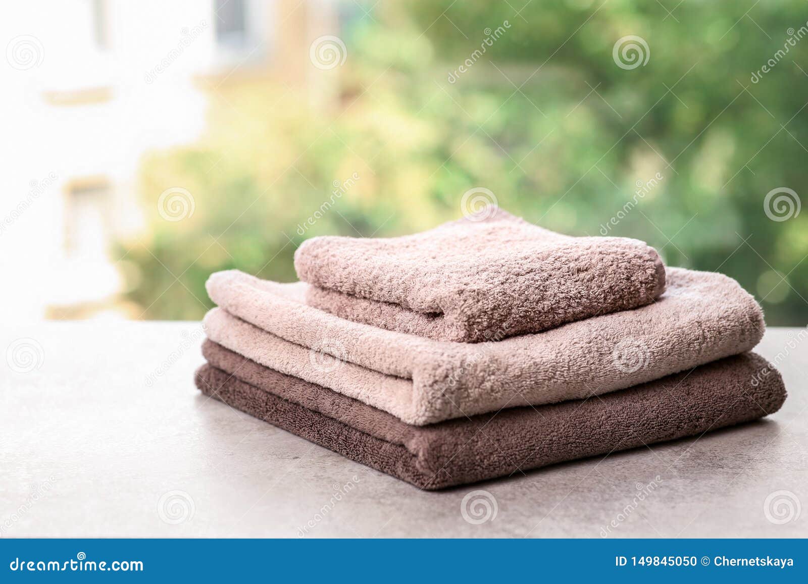 Stack of Clean Towels on Table Against Blurred Background. Stock Photo ...