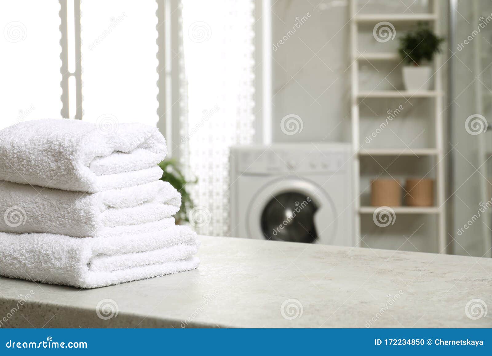Stack of Clean Towels on Table in Room. Space for Text Stock Photo ...