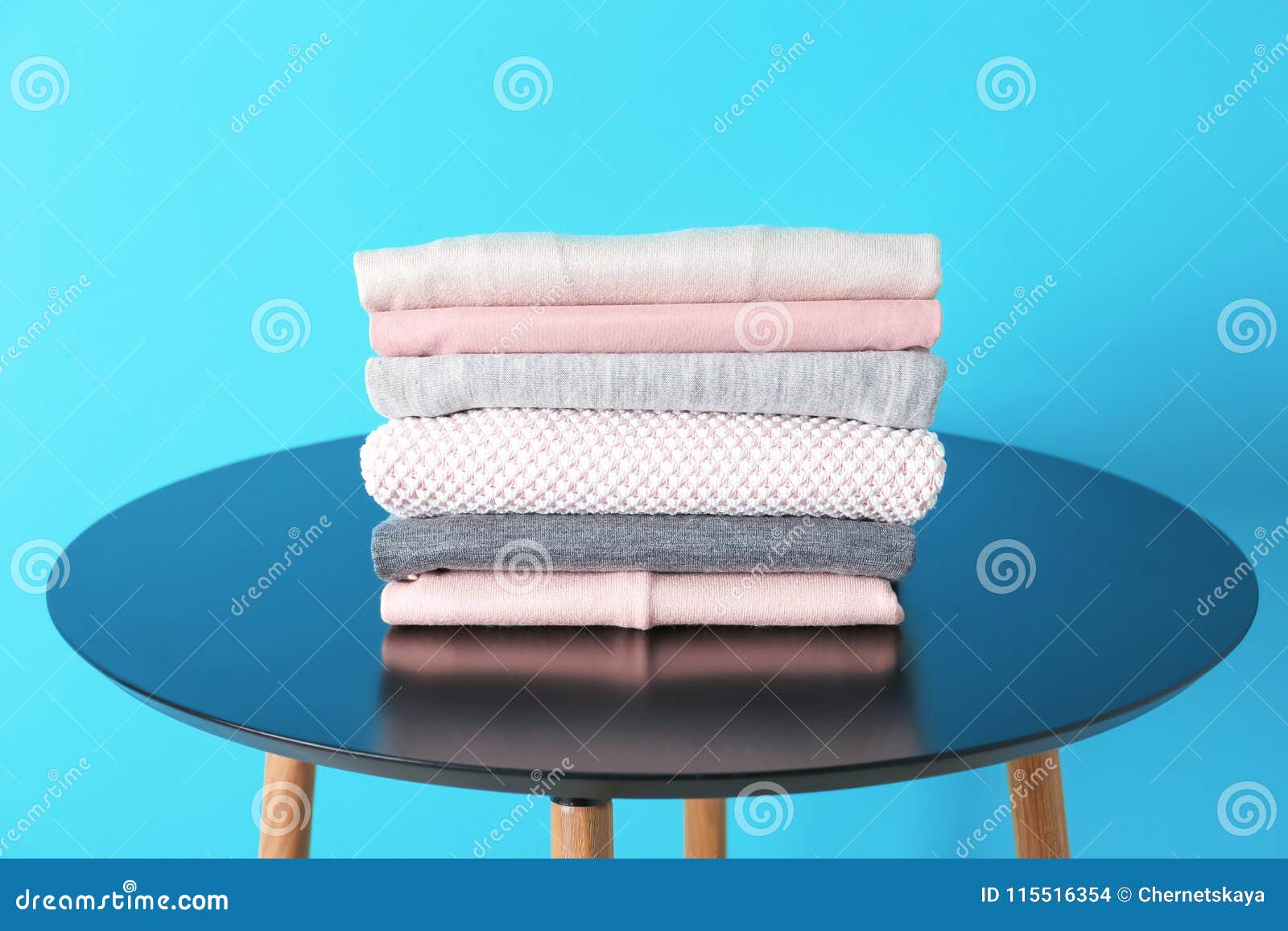 Stack of clothes on table stock photo. Image of fashion - 115516354