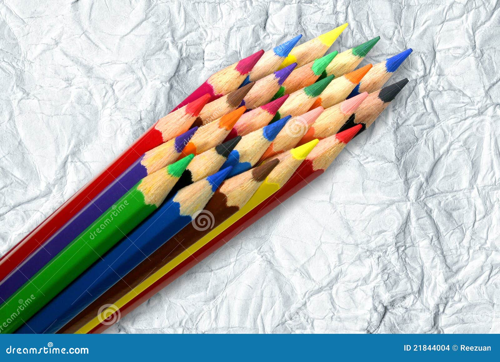 A Stack Of Colored Pencils On Crumpled Paper Backg Stock Photo - Image ...