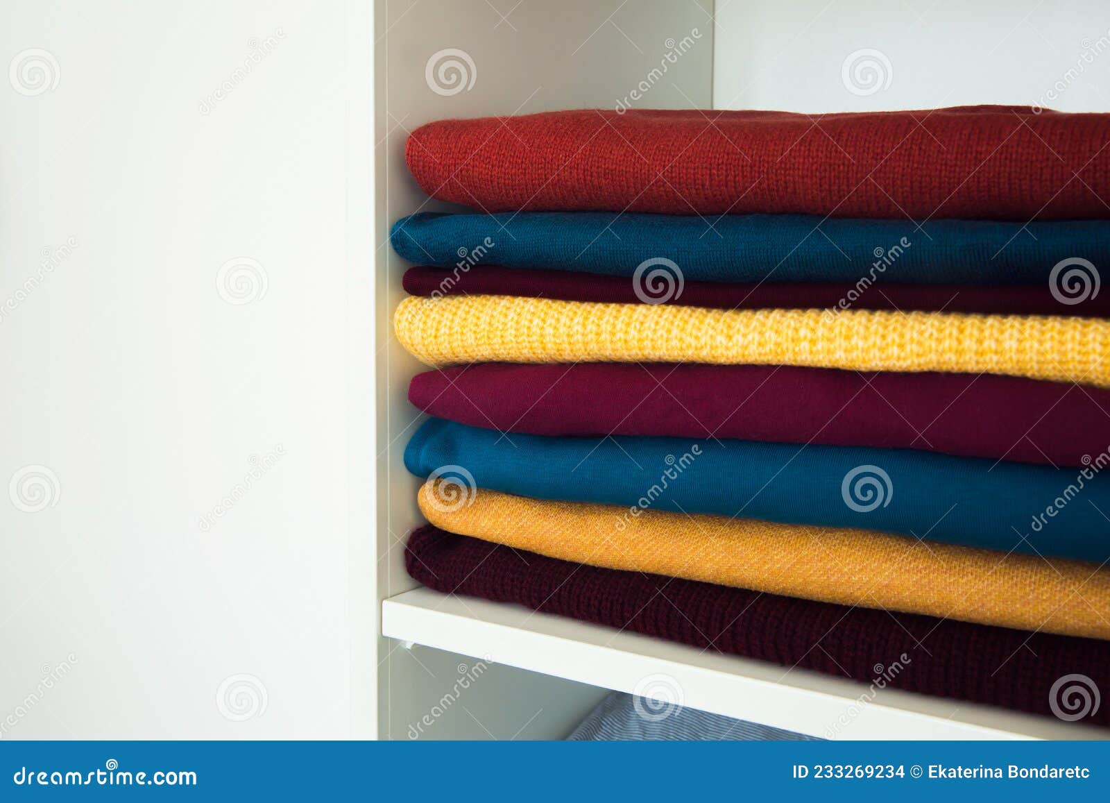 A Stack of Colored Things, Clothes, Neatly Stacked on a Shelf in a ...