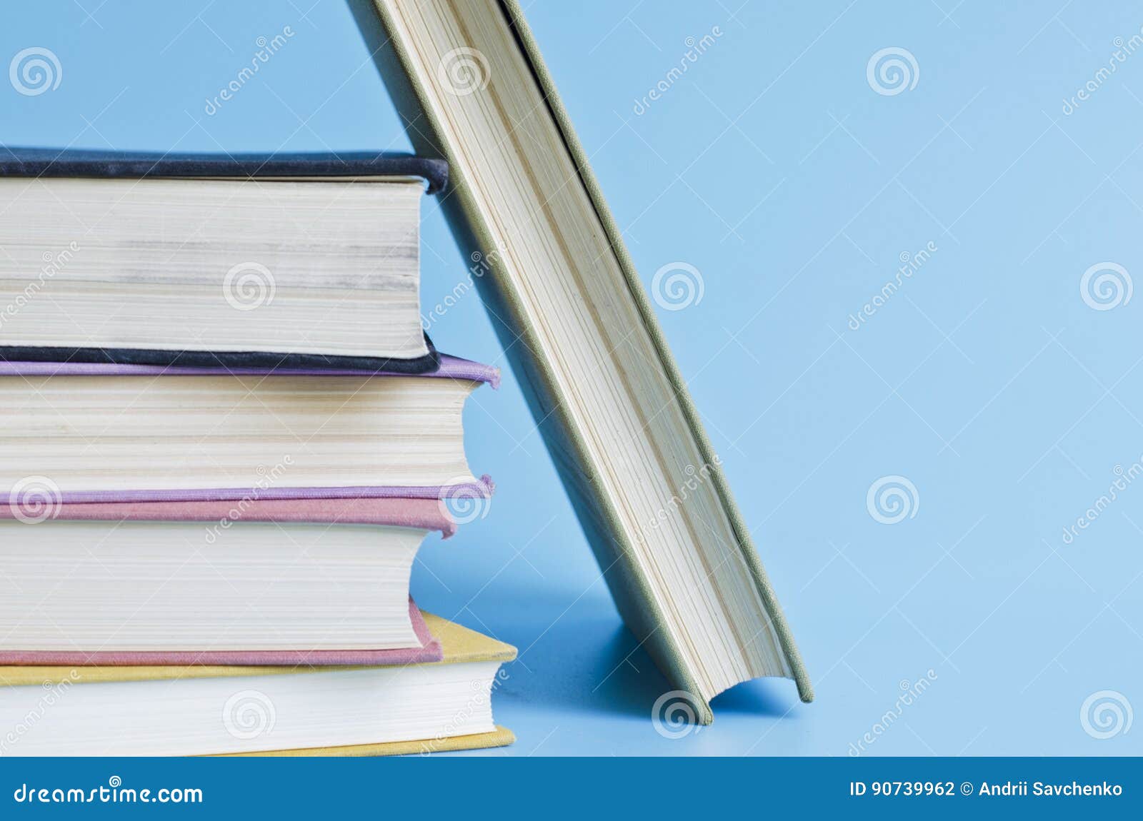 A Stack of Colorful Books on a Blue Background Stock Photo - Image of ...