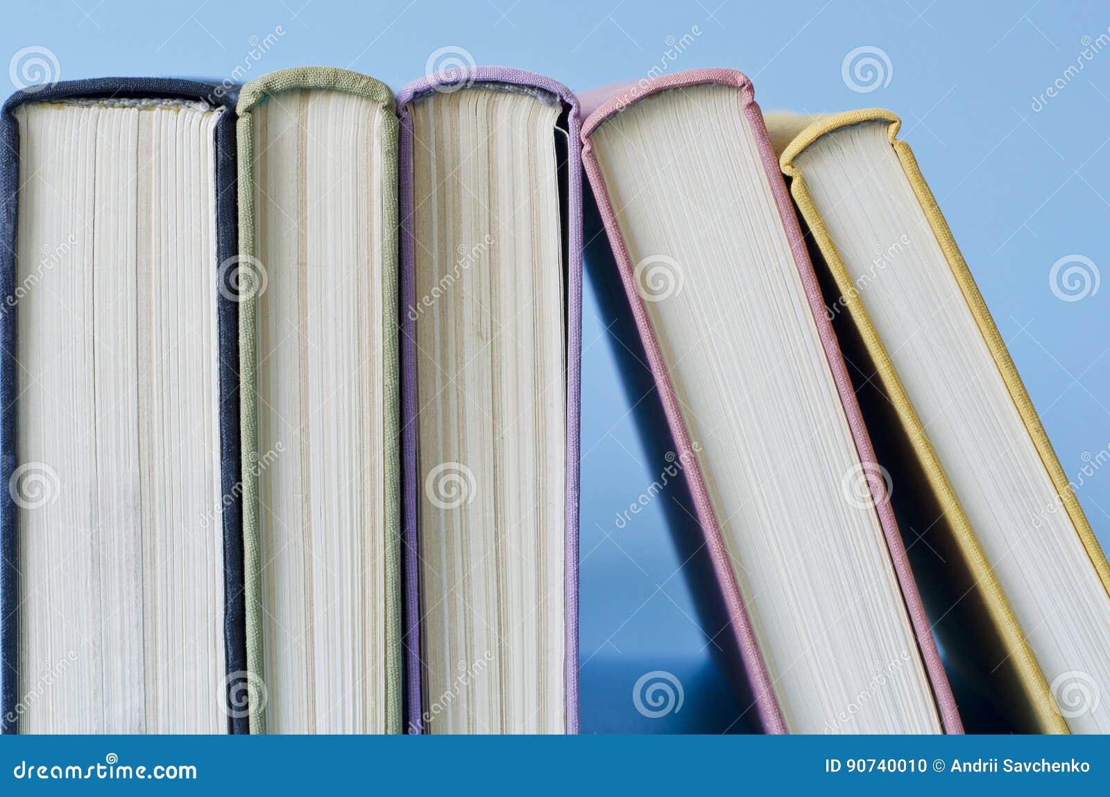 A Stack of Colorful Books on a Blue Background Stock Photo - Image of ...