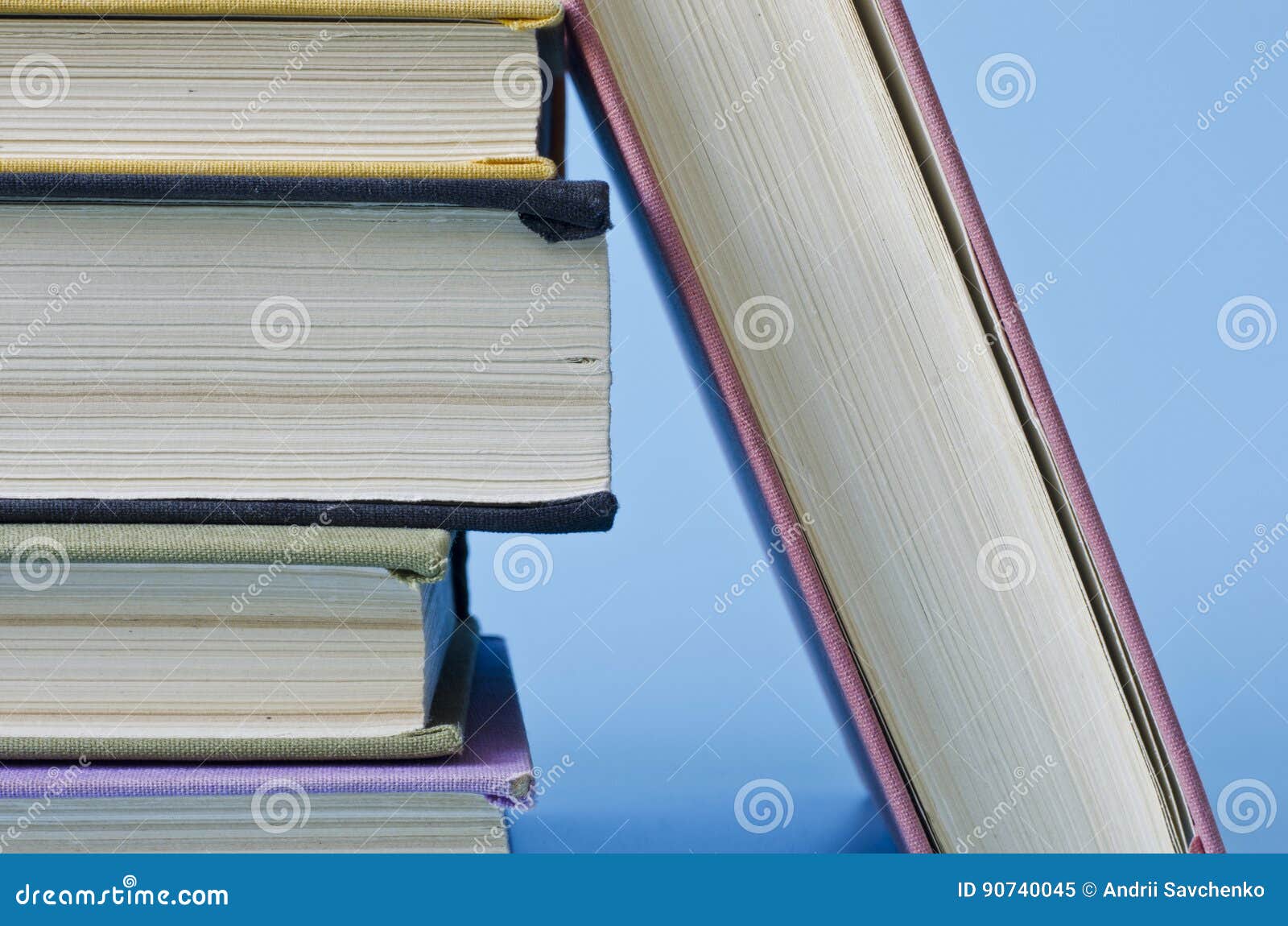 A Stack of Colorful Books on a Blue Background Stock Image - Image of ...
