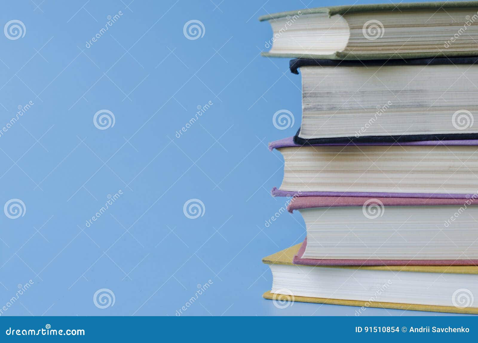 A Stack of Colorful Books on a Blue Background Stock Photo - Image of ...