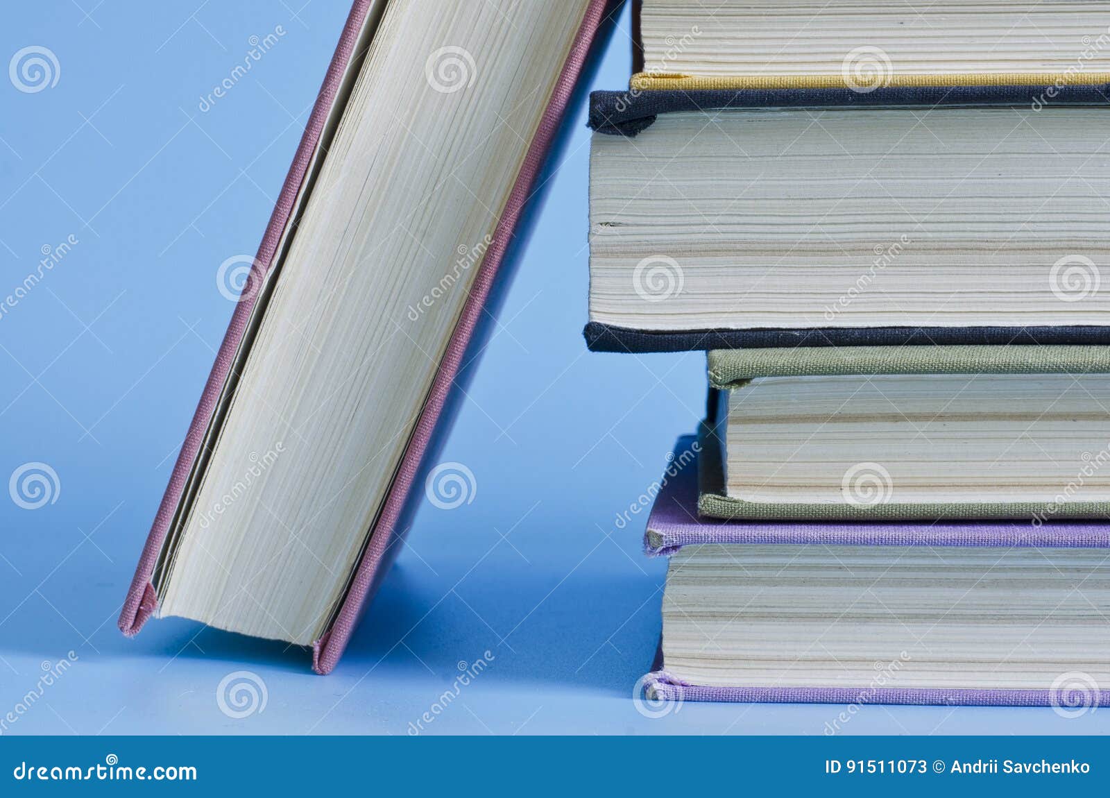 A Stack of Colorful Books on a Blue Background Stock Image - Image of ...