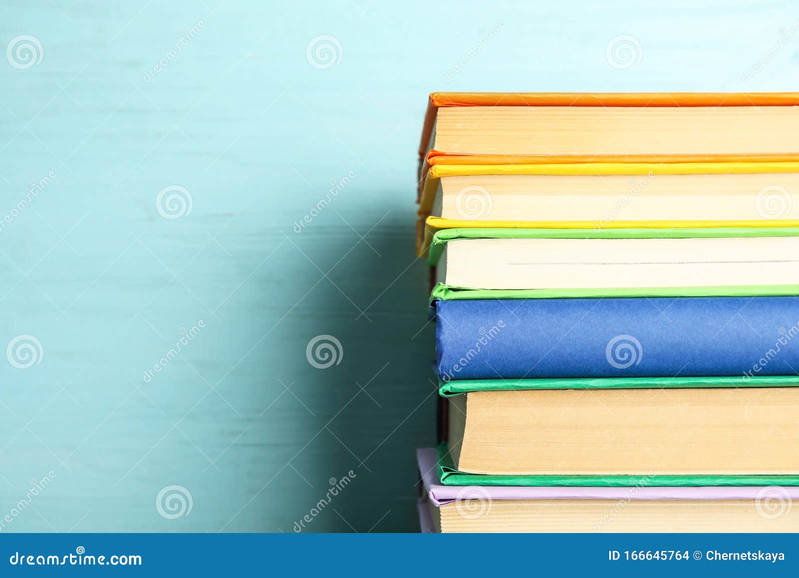 Stack of Colorful Books on Blue Wooden Background, Closeup. Space for ...