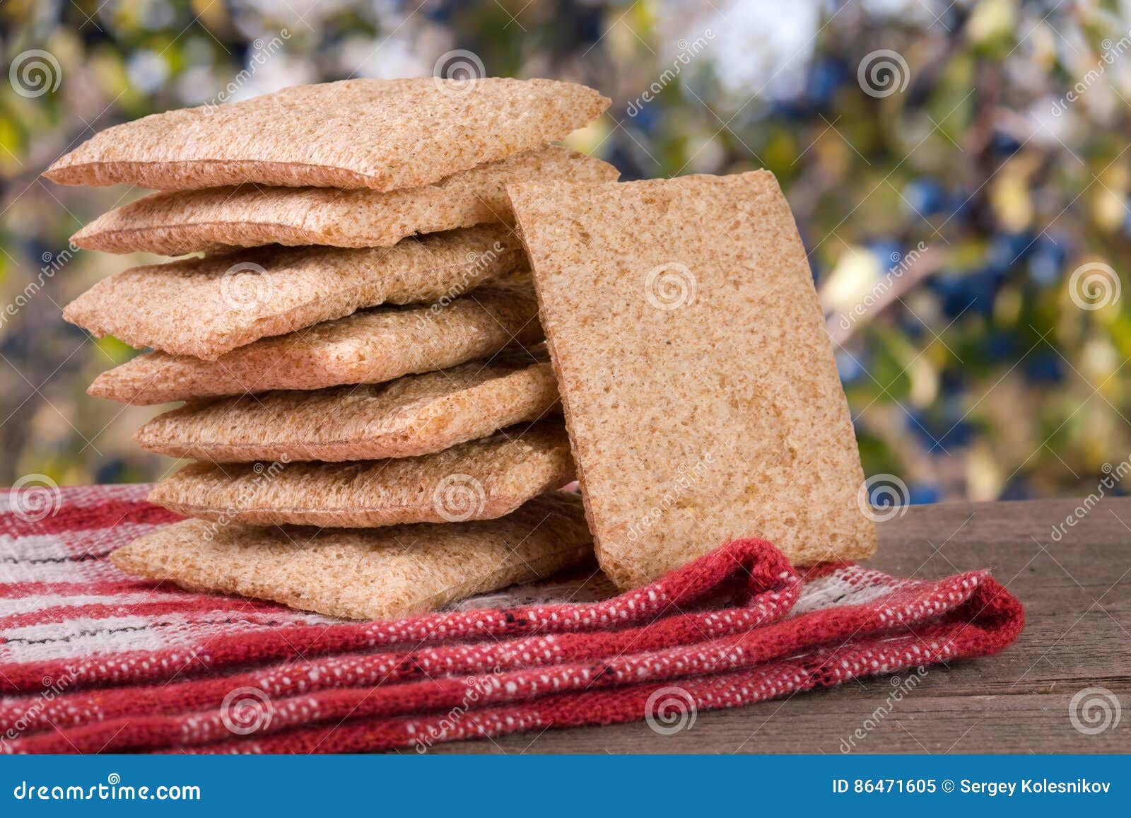 Stack of Crisp Bread on a Wooden Table with Blurred Garden Background ...