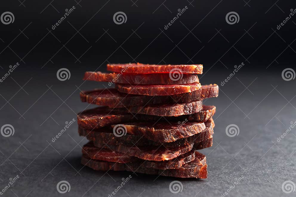 Stack of Delicious Beef Jerky on Dark Table, Closeup Stock Photo ...