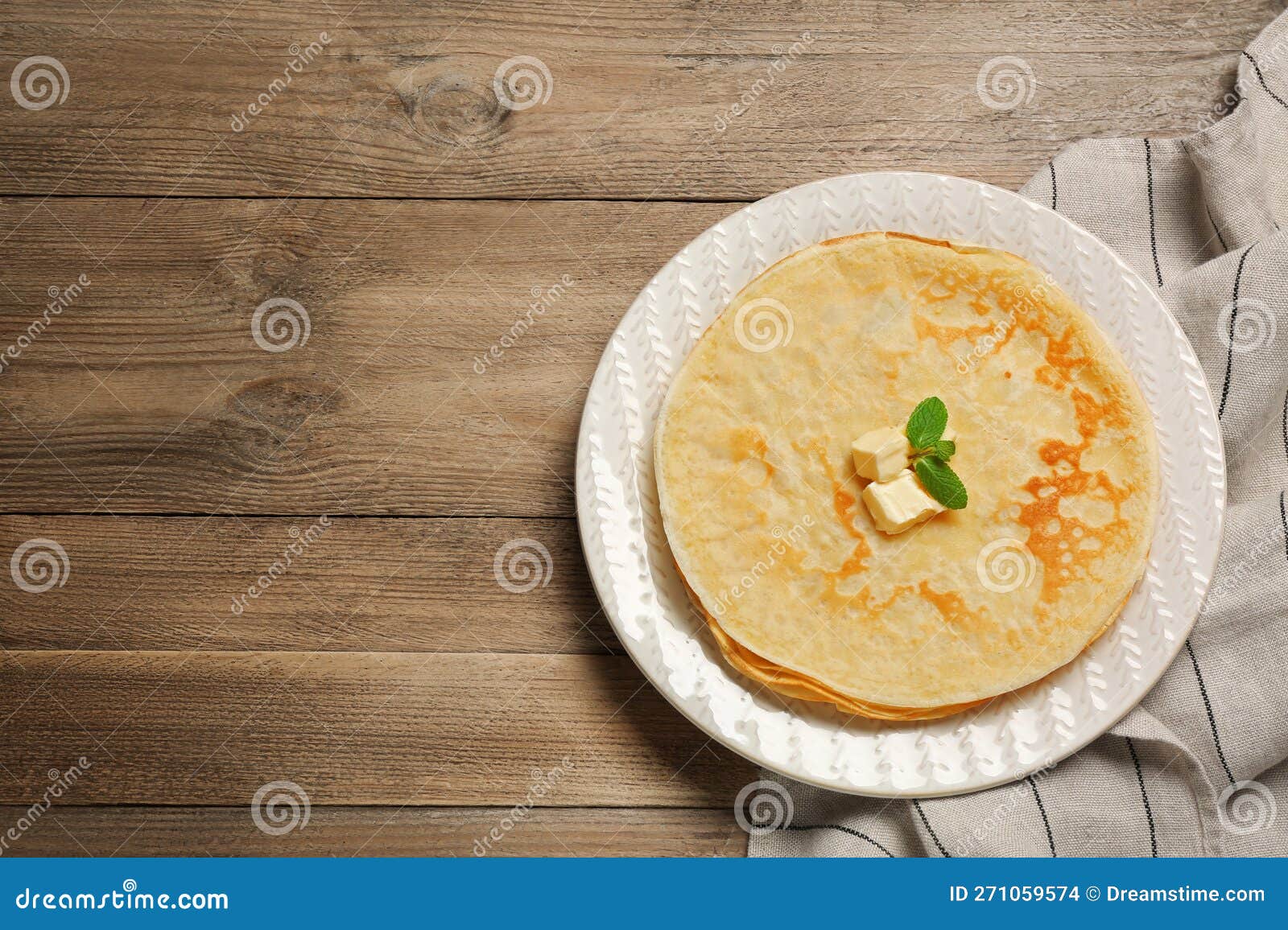 Stack of Delicious Crepes with Melting Butter and Mint on Wooden Table ...
