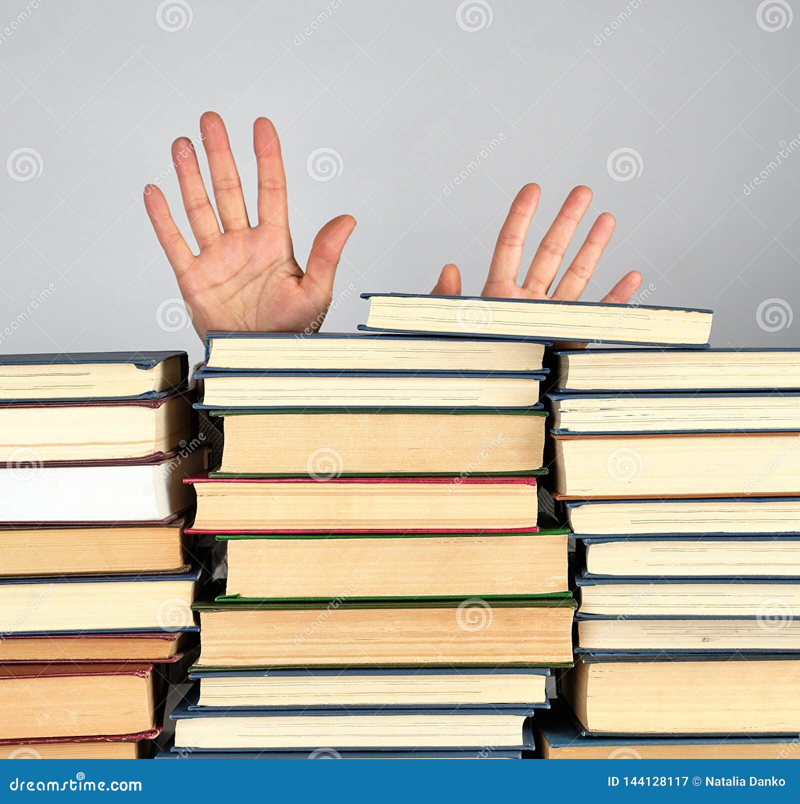 A Stack of Different Books on a Gray Background, Two Female Hands Stock ...