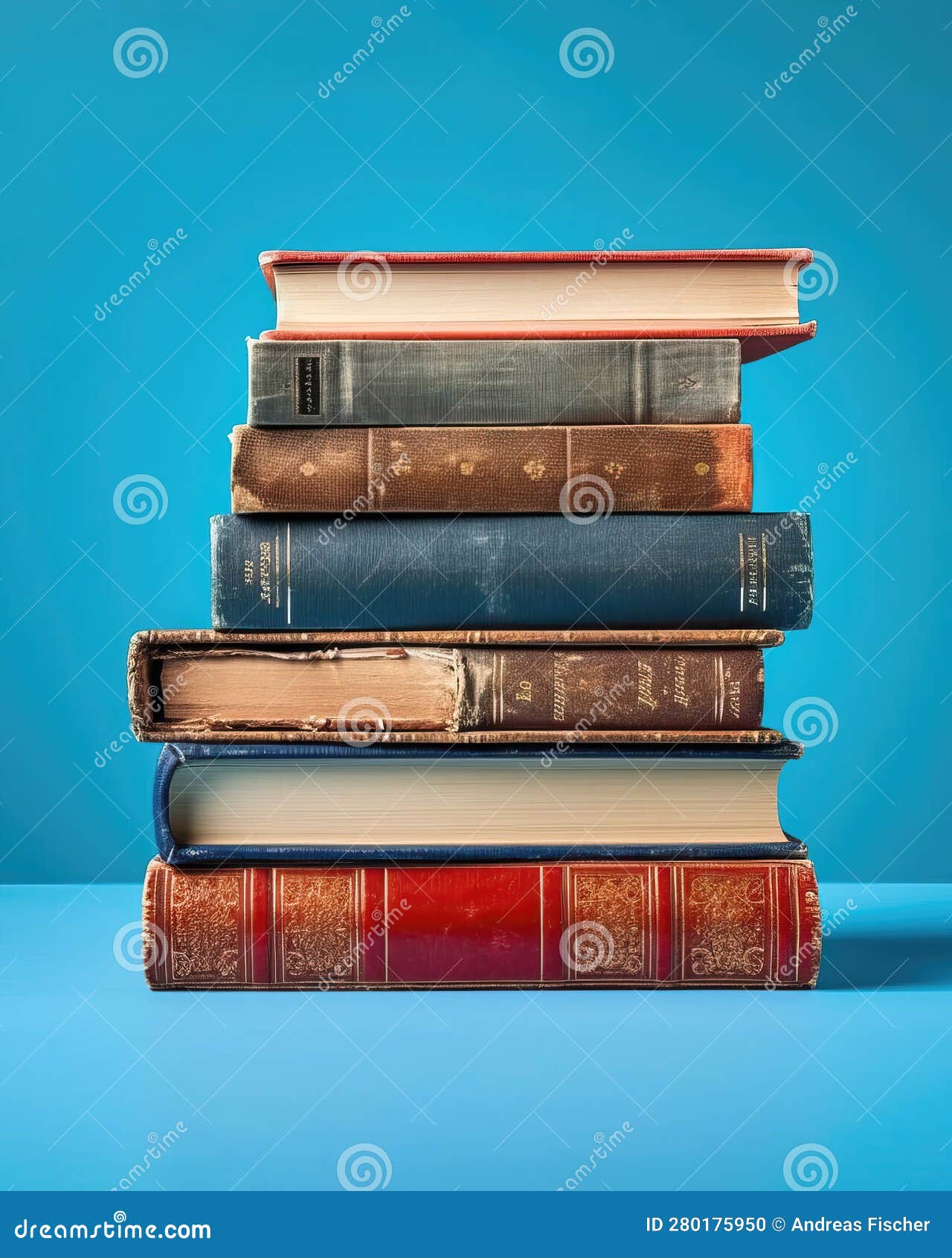 A Stack of Different Books by Size and Color on a Blue Background ...