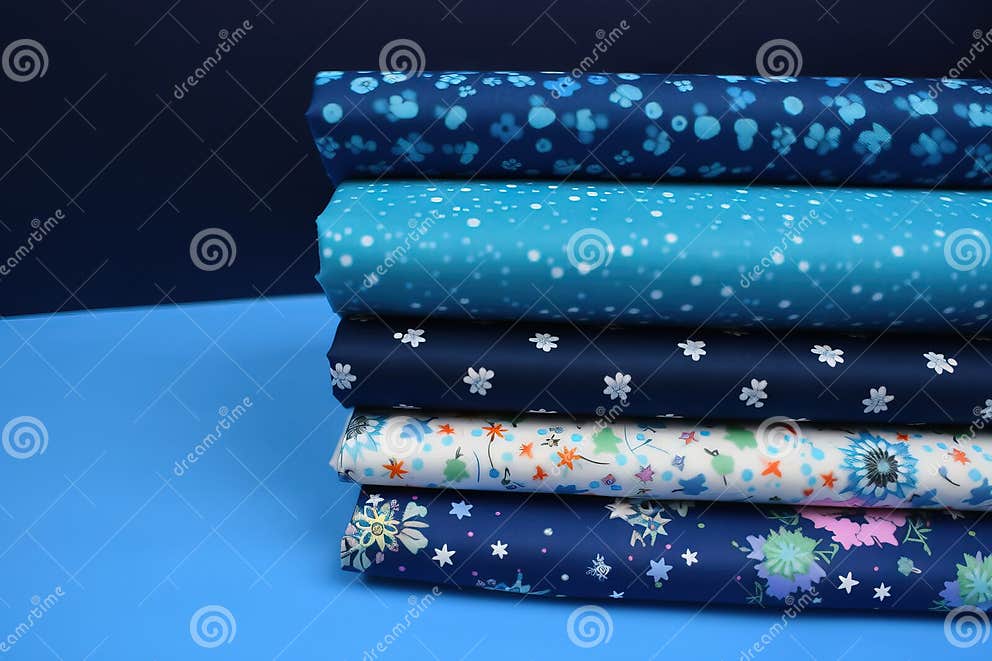 A Stack of Different Colored Fabrics on a Blue Surface with a Blue ...